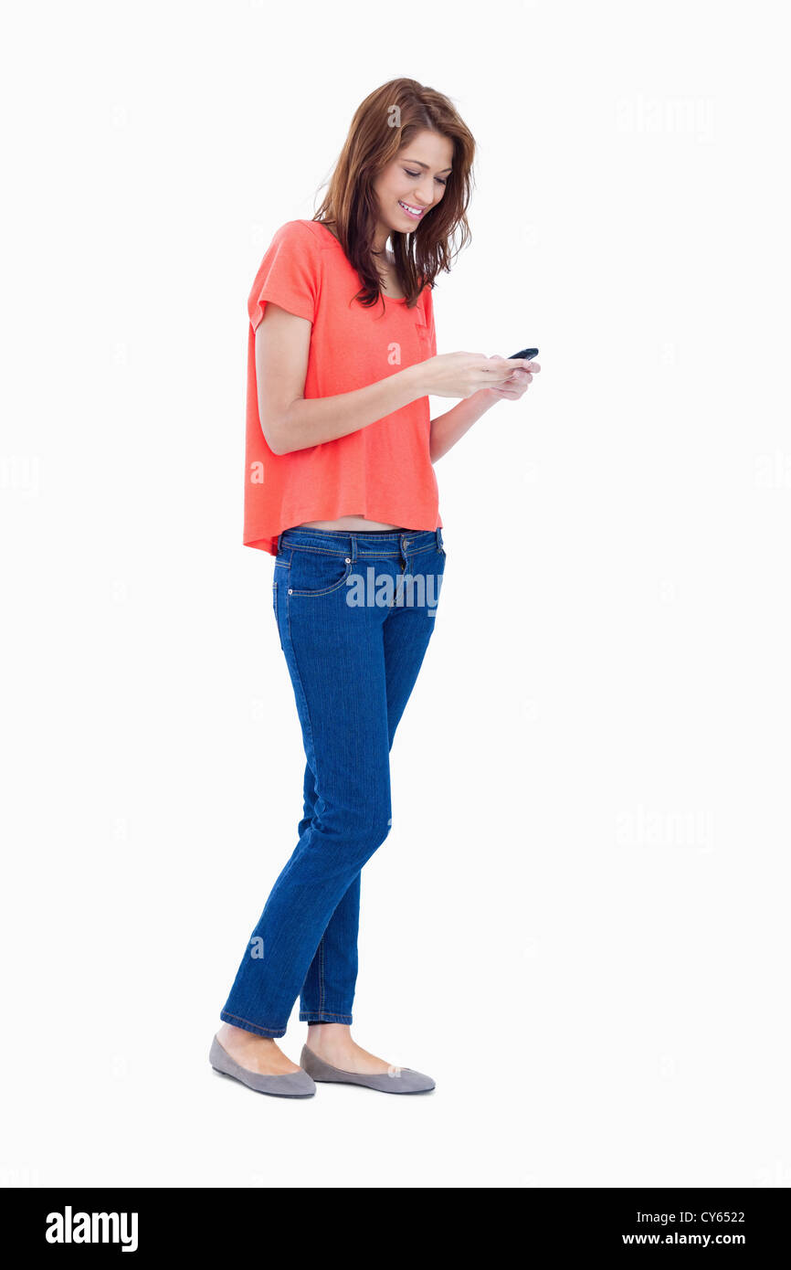 Teenage girl standing upright while sending a text Stock Photo - Alamy