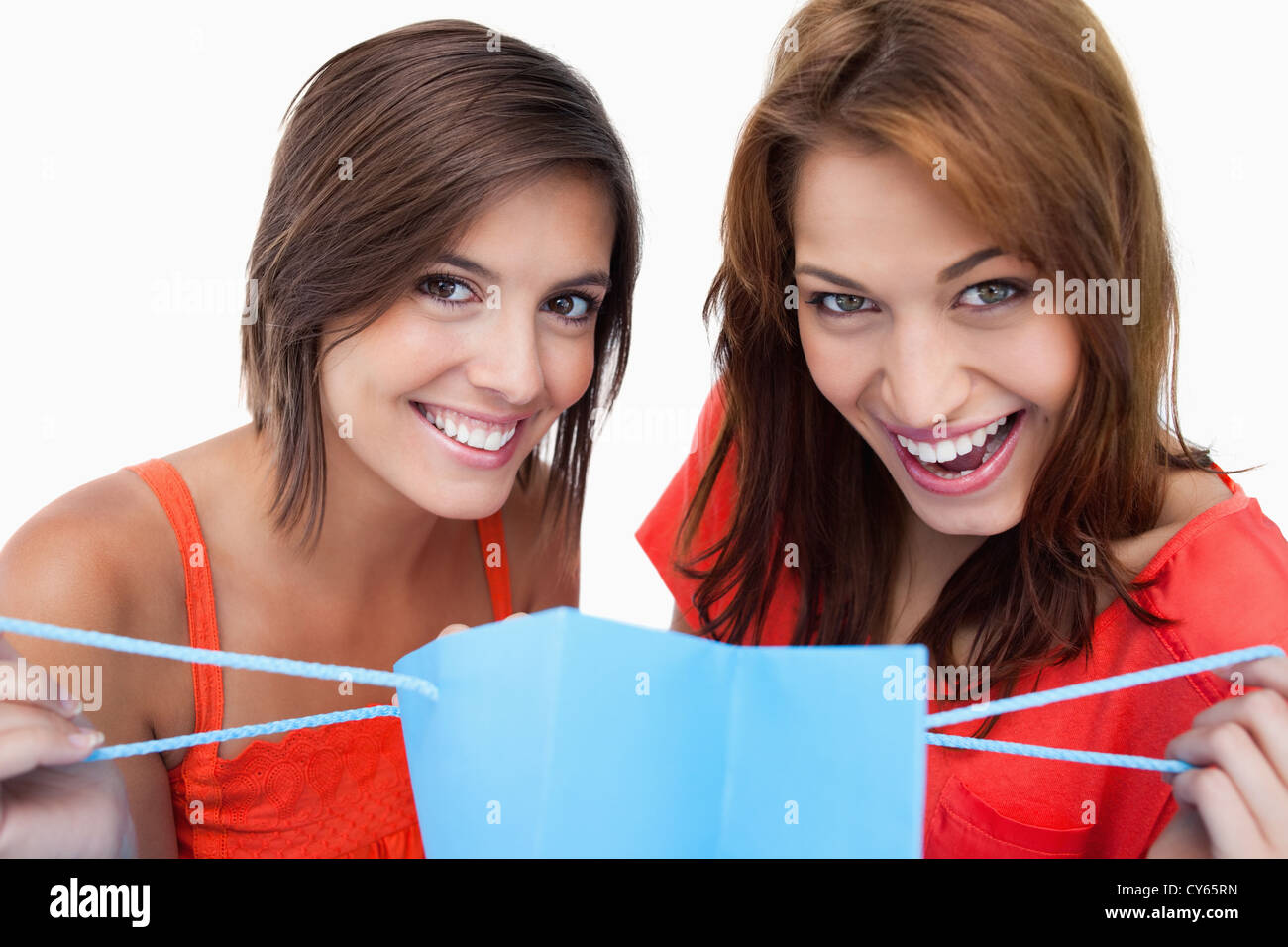 Two teenage girls holding a purchase bag while smiling Stock Photo - Alamy