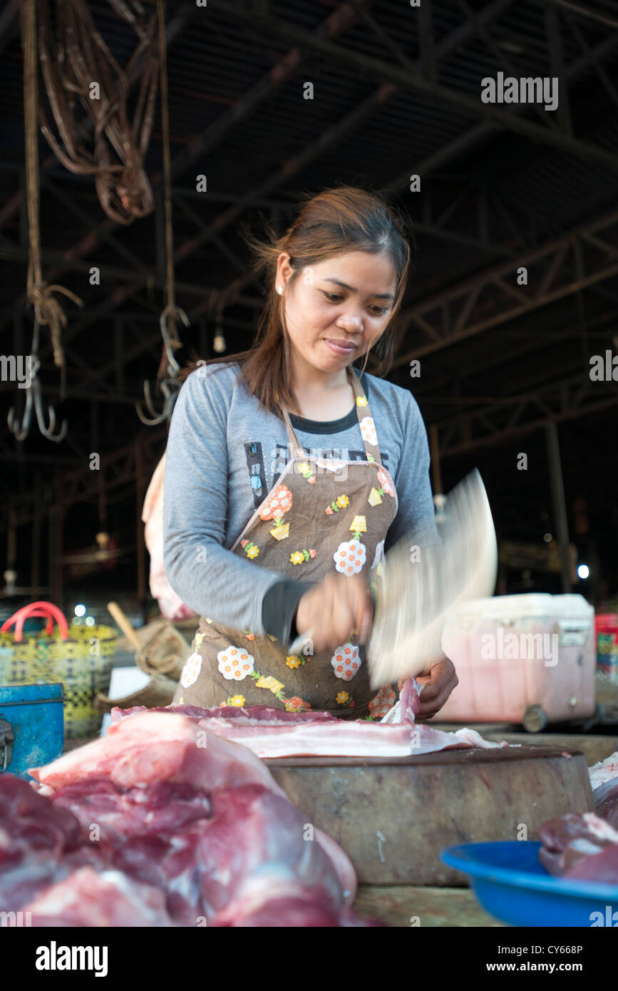A butcher prepares meat at her market stall in Sisophon, Cambodia Stock ...