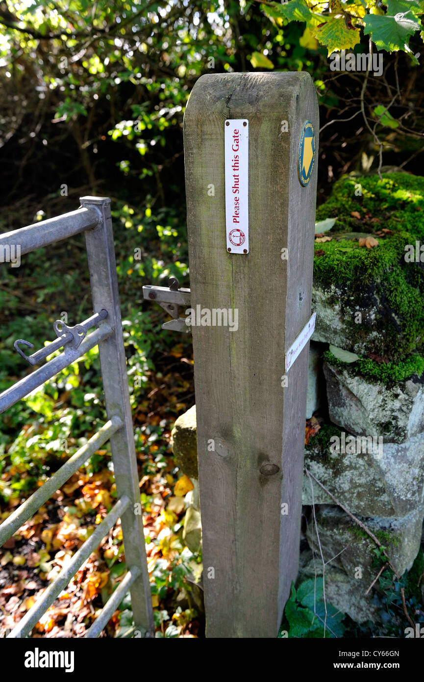 Wooden gate post and metal gate leading to a public footpath with a ...