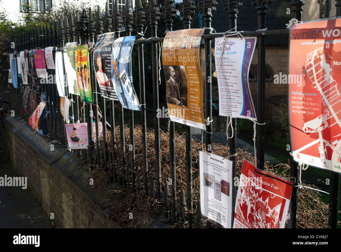 Large number of bill posters / advertising posters on black railings in ...