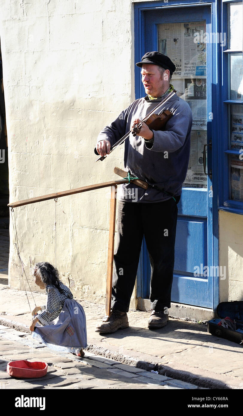Street busker playing a musical instrument and entertaining the general ...