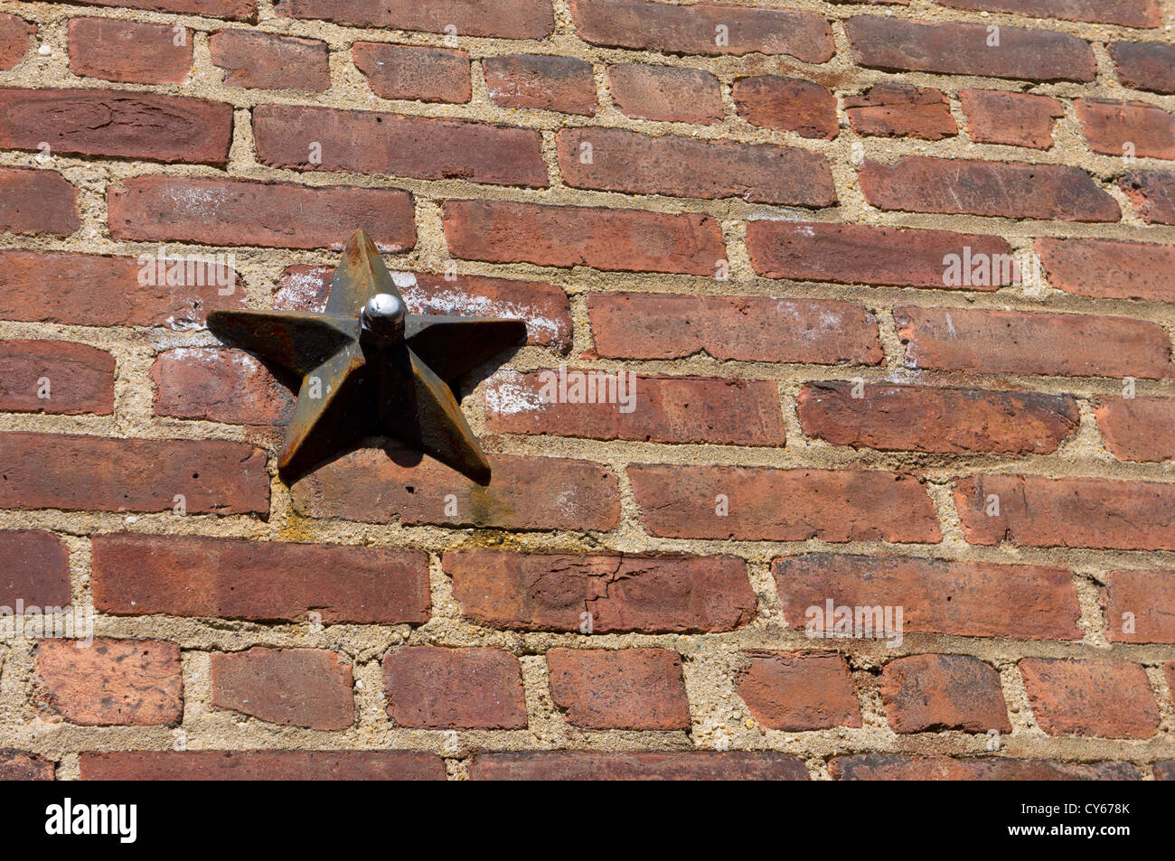 A rusty star shaped wall tie on a red brick wall along the route of the ...