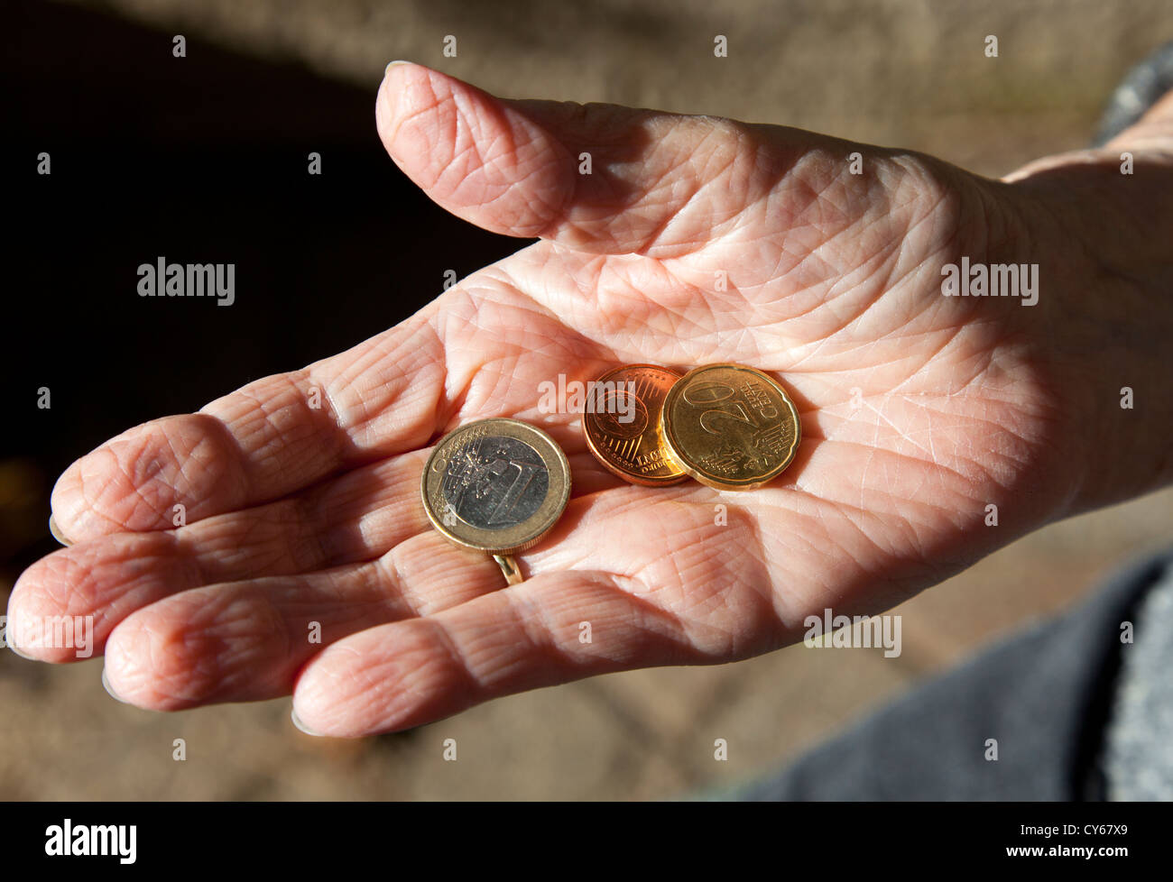 Old lady holding Euro coins Stock Photo - Alamy