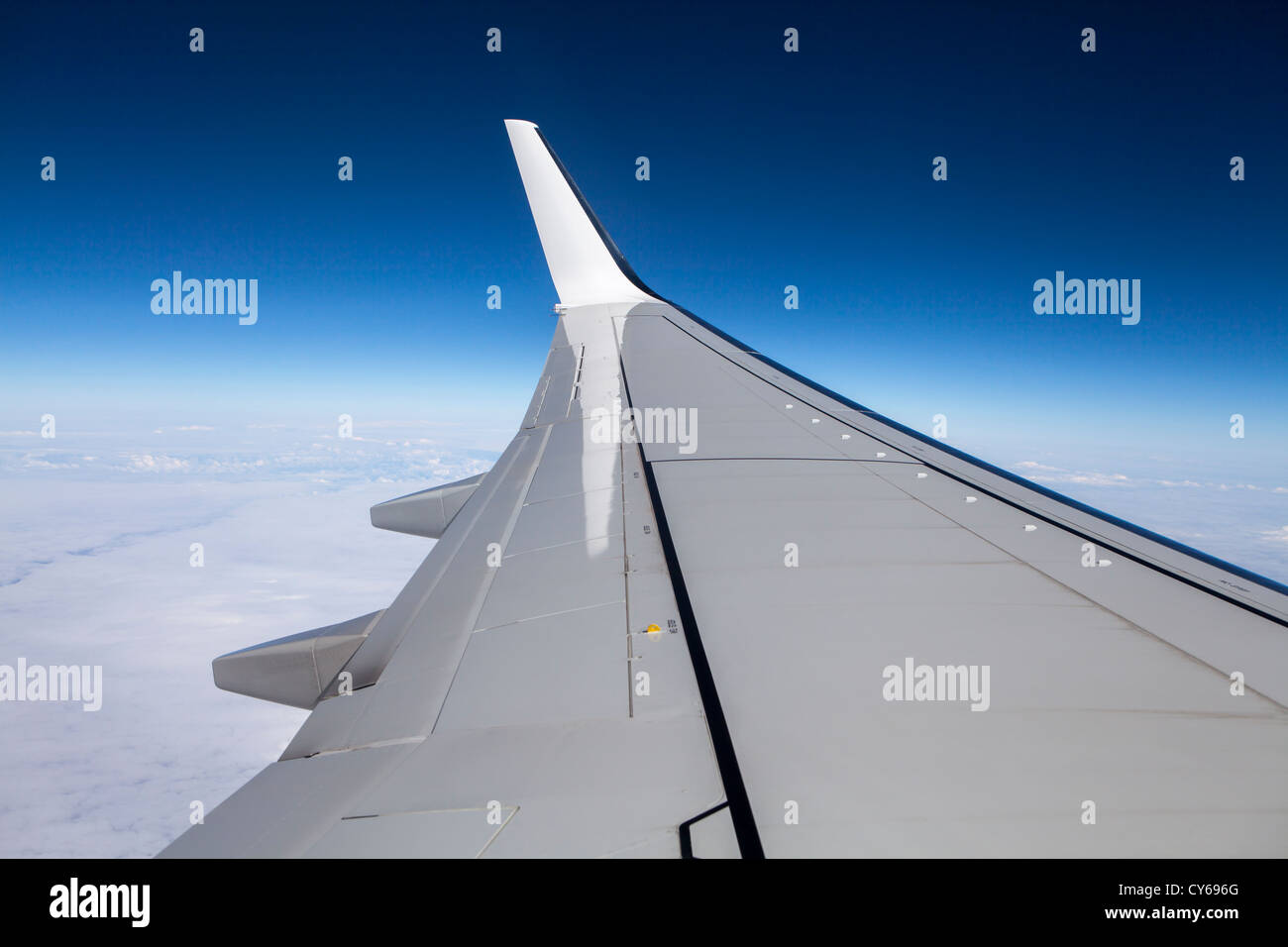 Airplane Boeing-737 wing as seen from a plane window with a bright blue ...