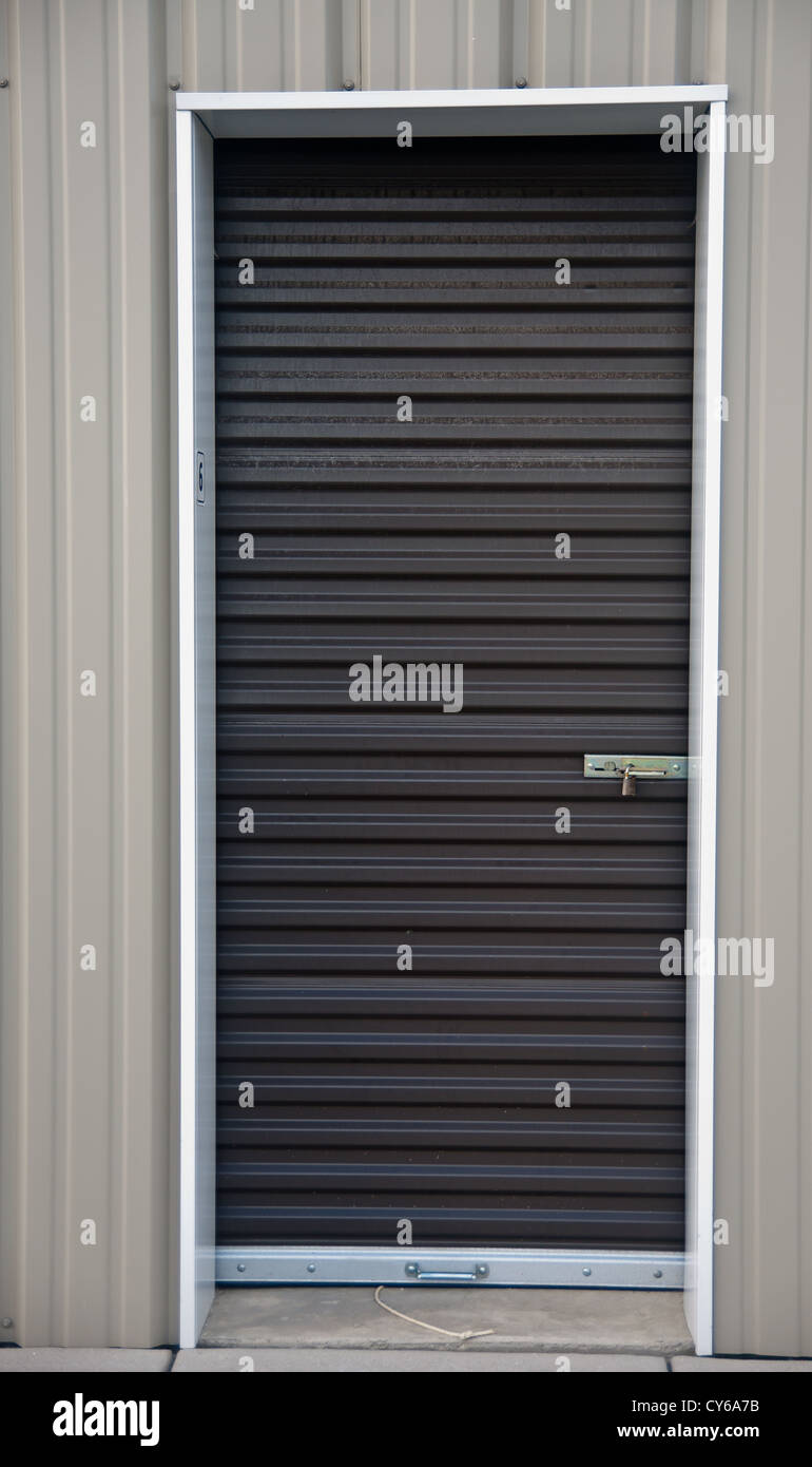 Brown metal door with padlock, of an outdoor storage unit Stock Photo ...