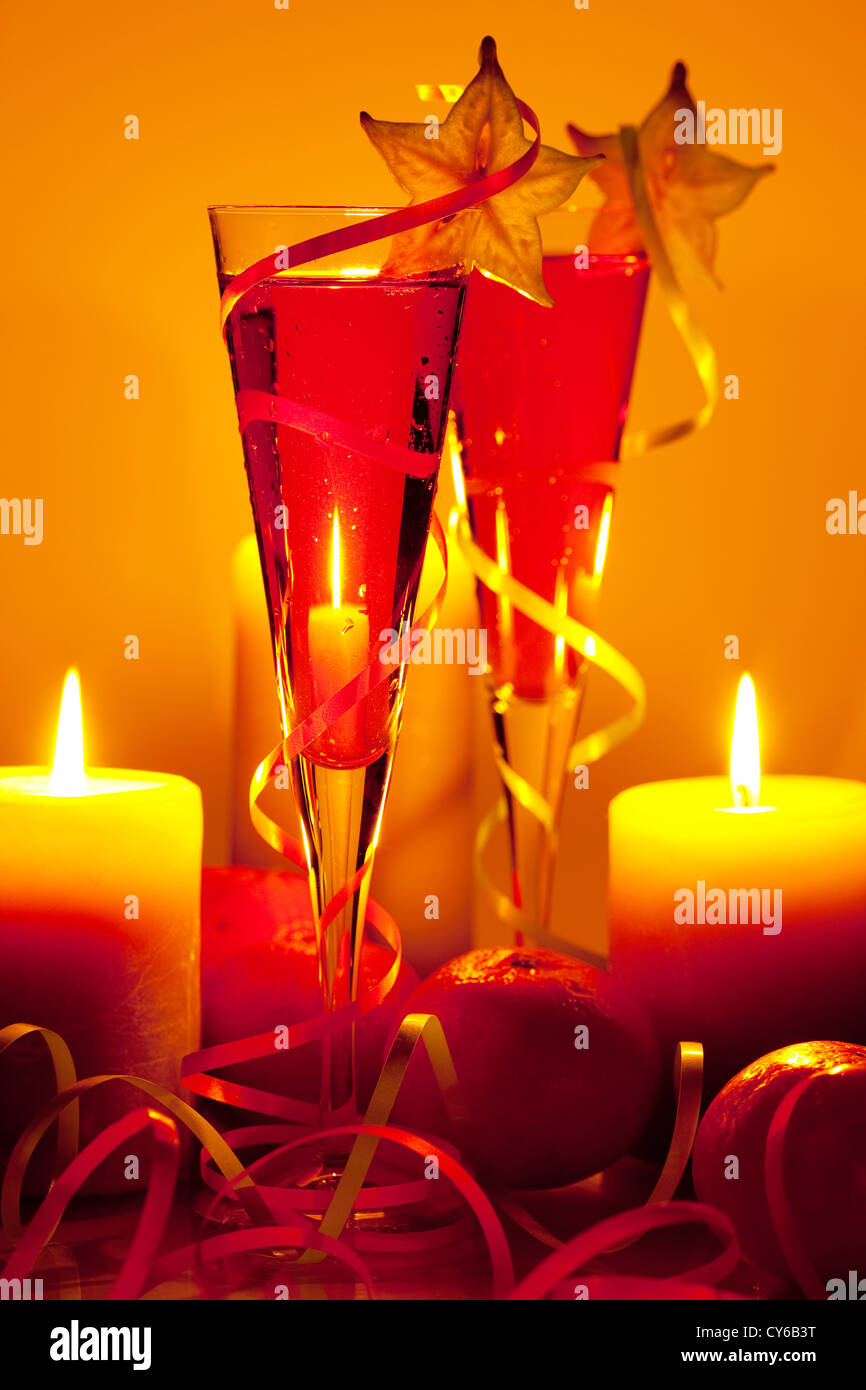 Two orange alcohol cocktails with mandarines and light candles isolated ...
