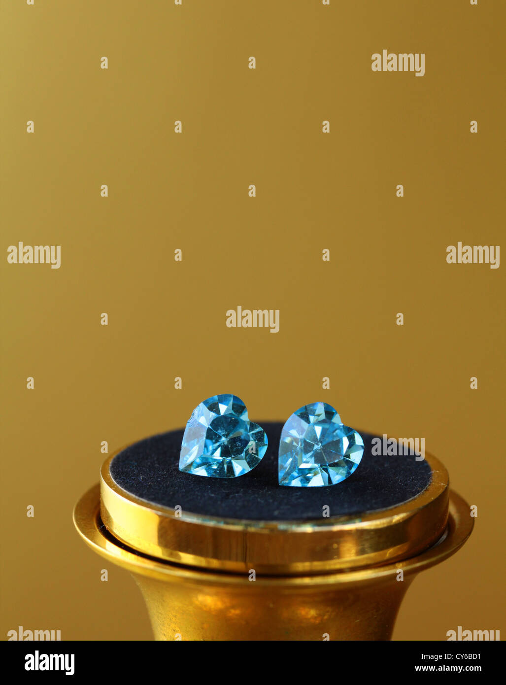 gold earrings stud with diamonds on gold background Stock Photo - Alamy