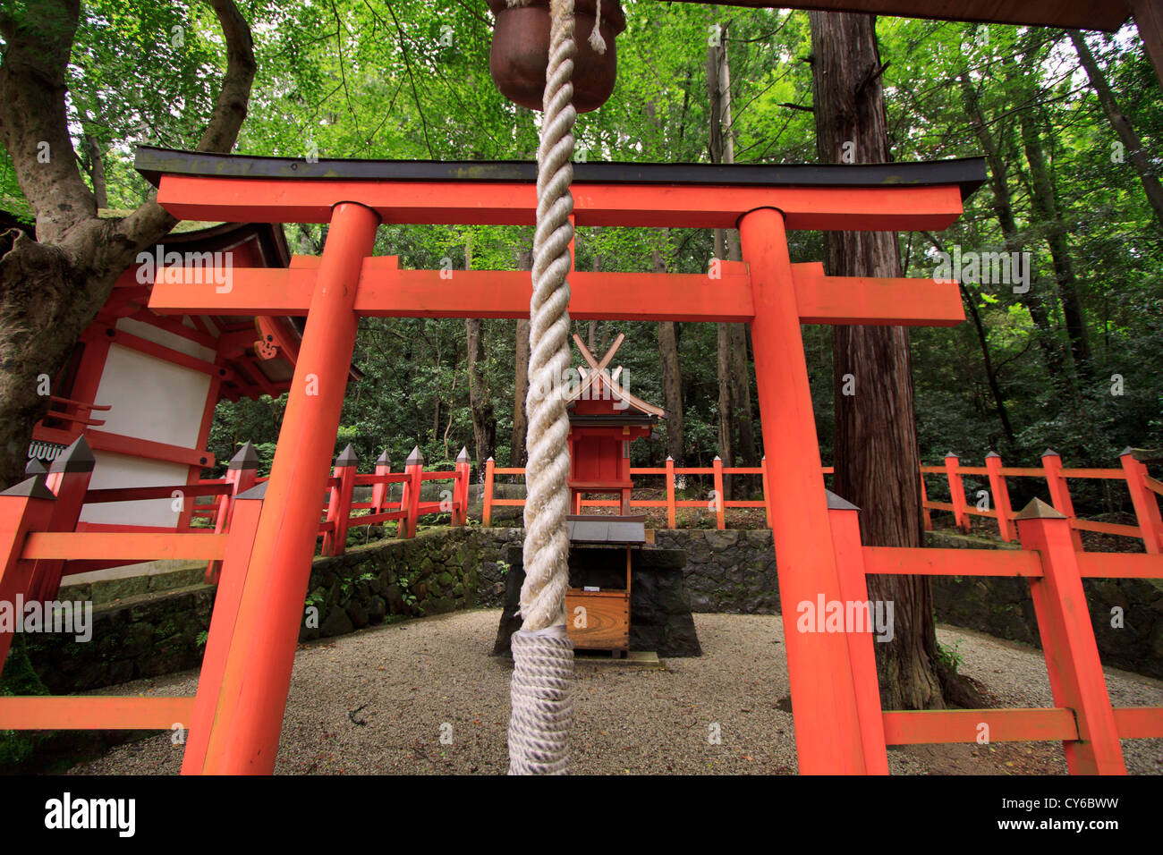 A traditional red torii gate at the entrance to a small Shinto shrine ...