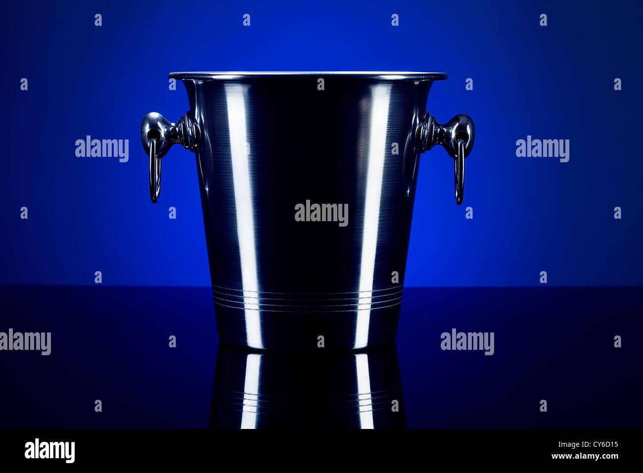 empty champagne bucket on a mirror with blue background Stock Photo - Alamy