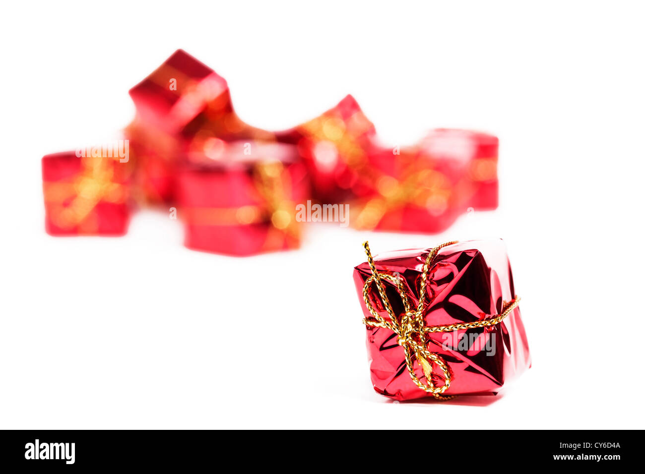 small red christmas present in front of others on white background ...