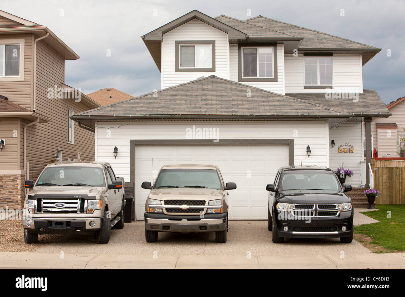 A family with three huge gas guzzling cars in Fort mcMurray the centre ...