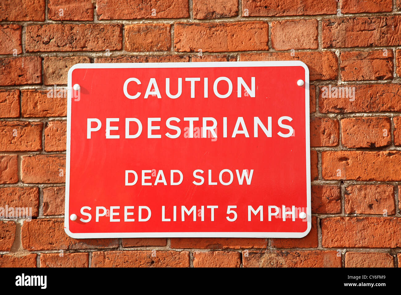 Caution pedestrians - dead slow sign Stock Photo - Alamy