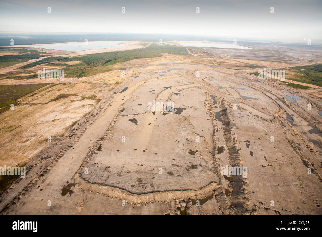Soil overburden being removed to reach the tar sands beds in an open ...