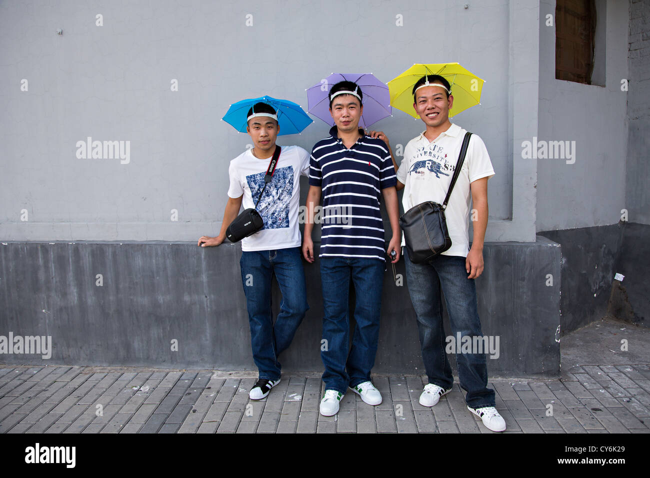 A group of Chinese tourists wearing umbrella hats in Beijing, China ...