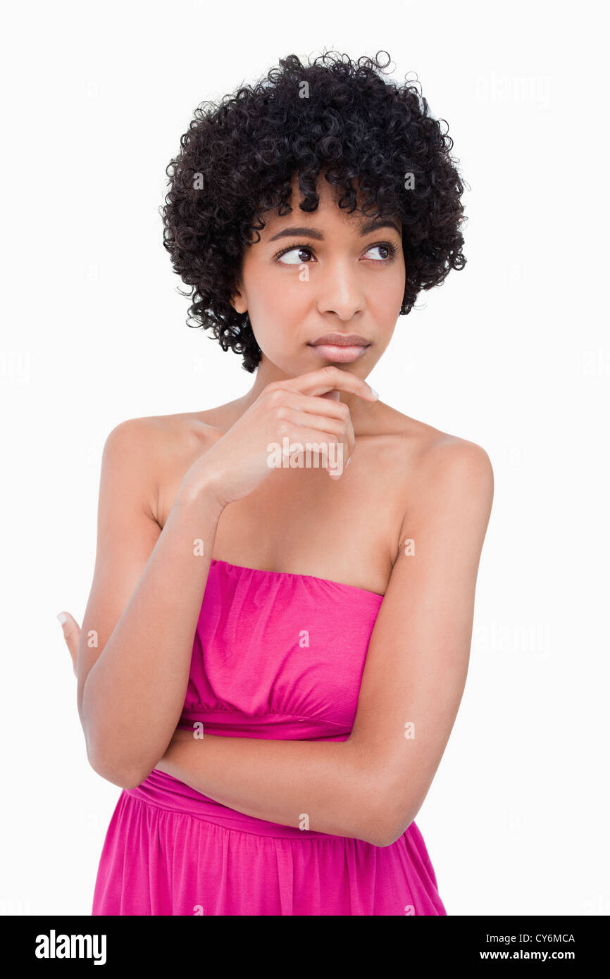 Thoughtful teenage girl putting her hand on her chin while looking to ...