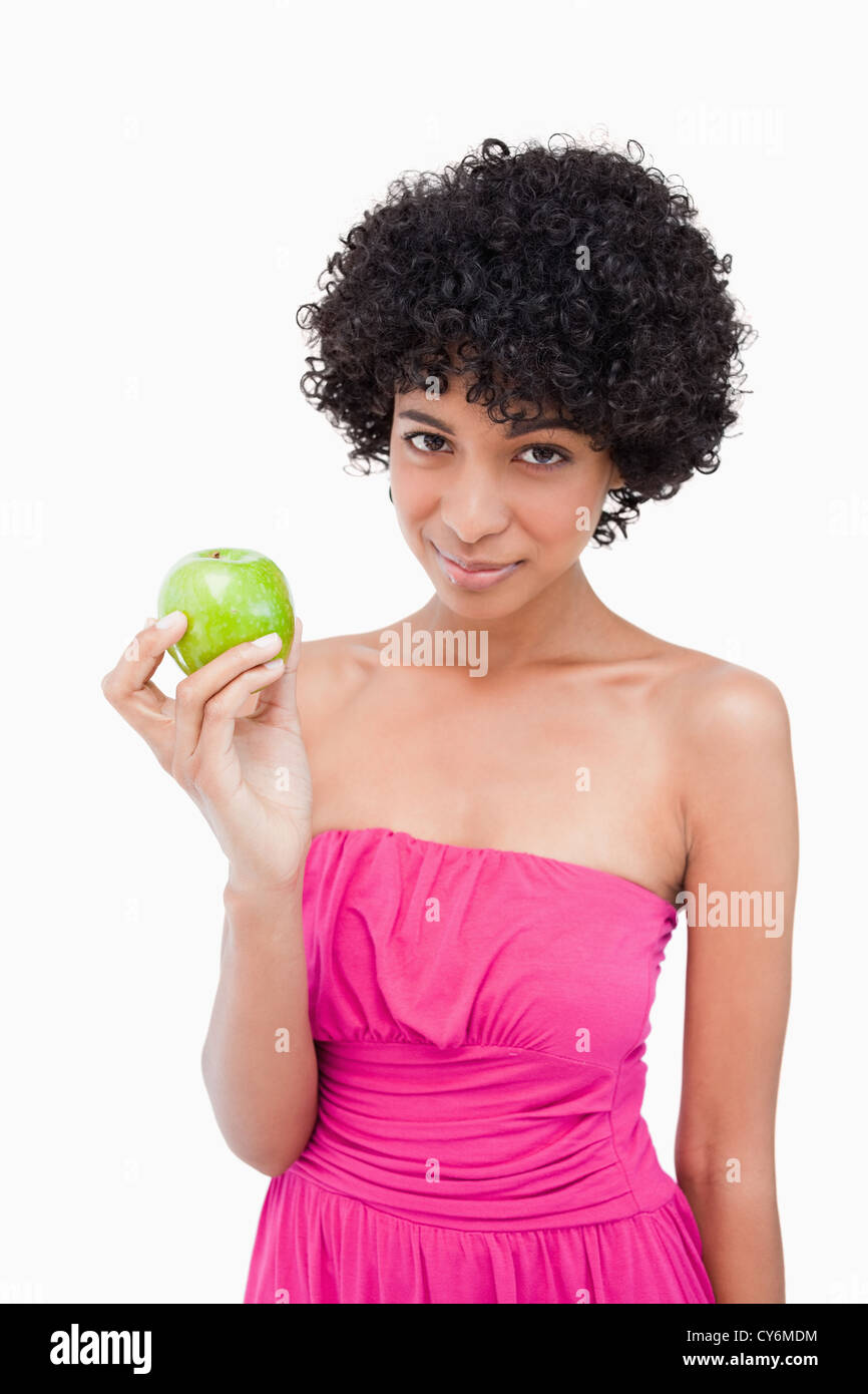 Attractive young woman showing a green apple while looking at the ...