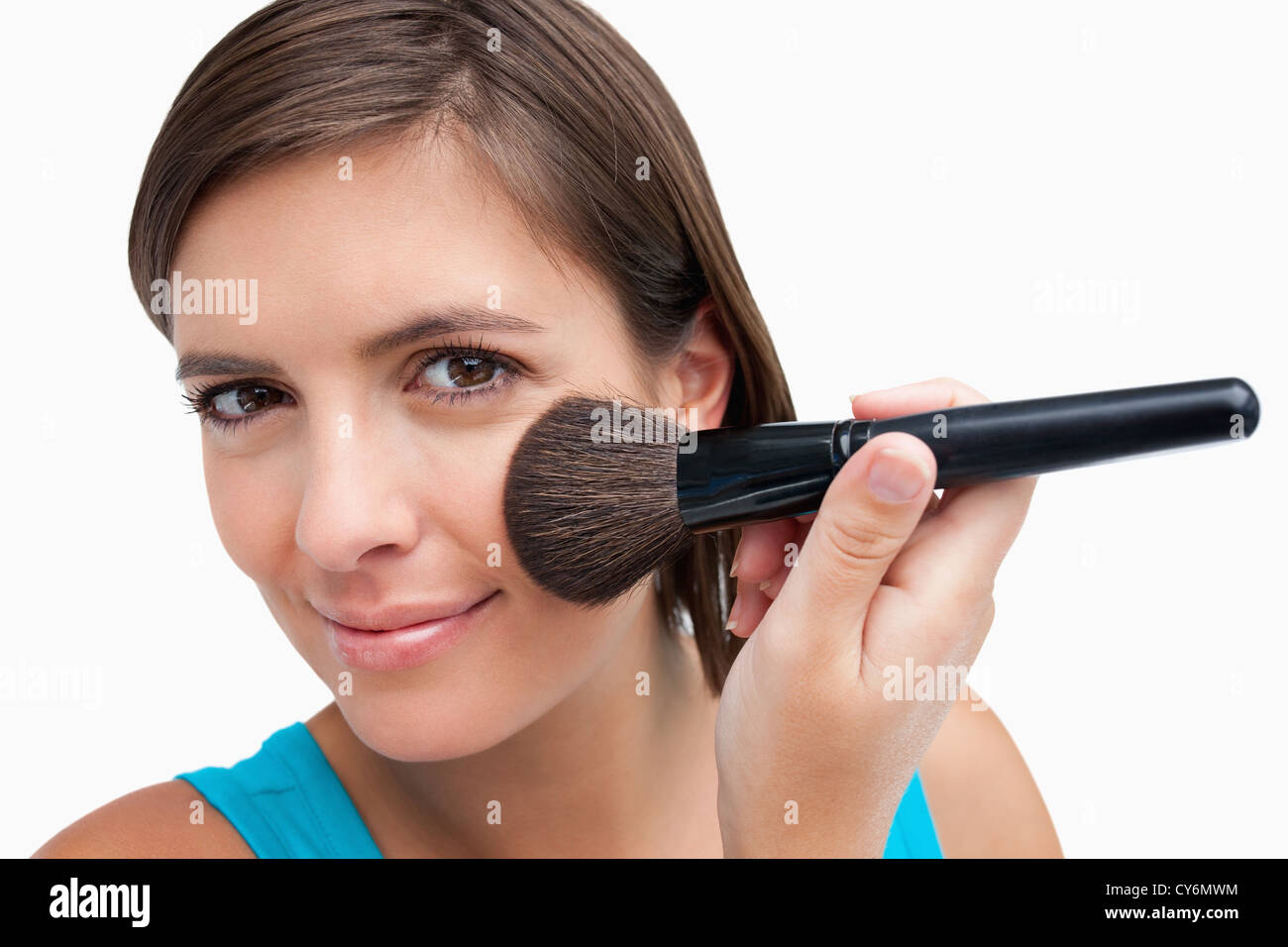 Smiling teenager using a powder brush with a mischievous look Stock ...