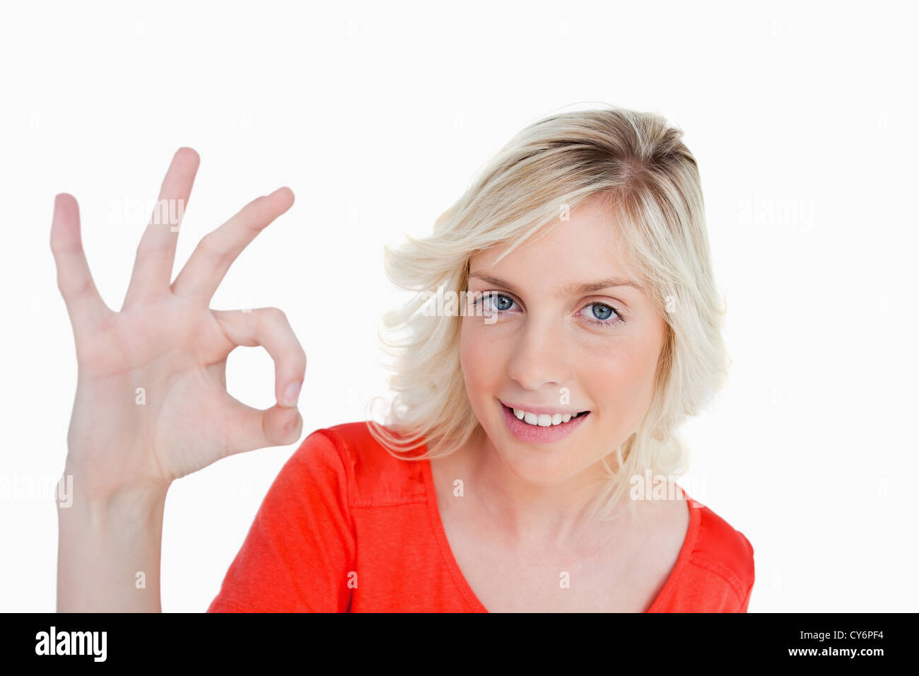 Smiling woman showing the OK sign while looking straight at the camera ...