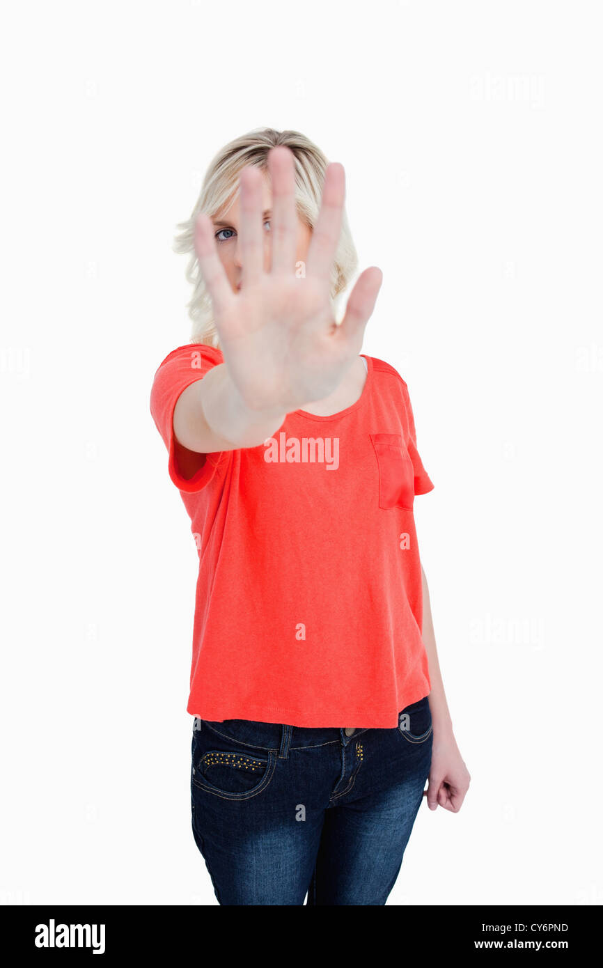 Young blonde woman trying to hide herself behind her hand Stock Photo ...
