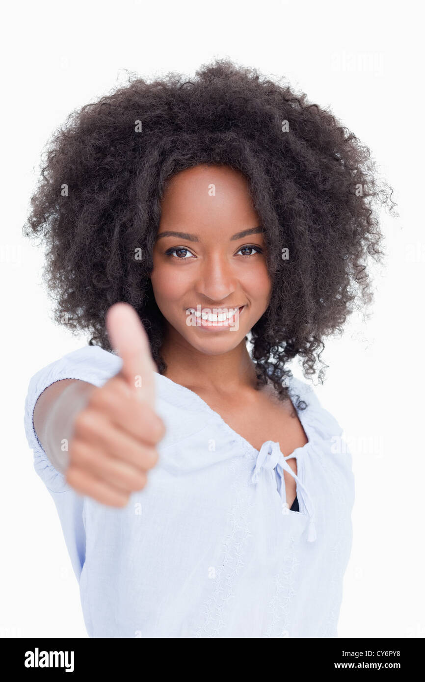 Young smiling woman standing upright while placing her thumbs up Stock ...
