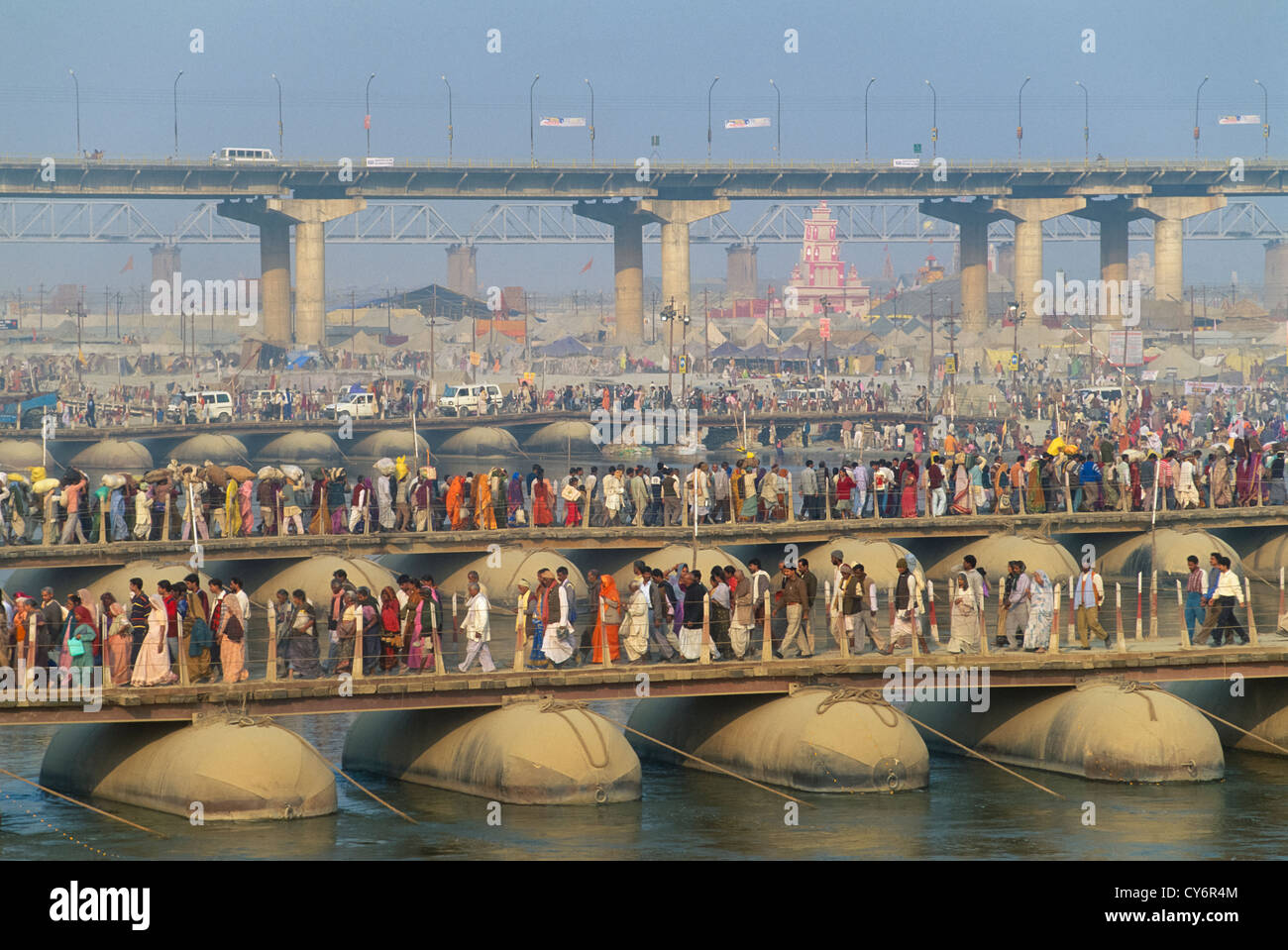 Pilgrims crossing pontoon bridges across the River Ganges with the ...