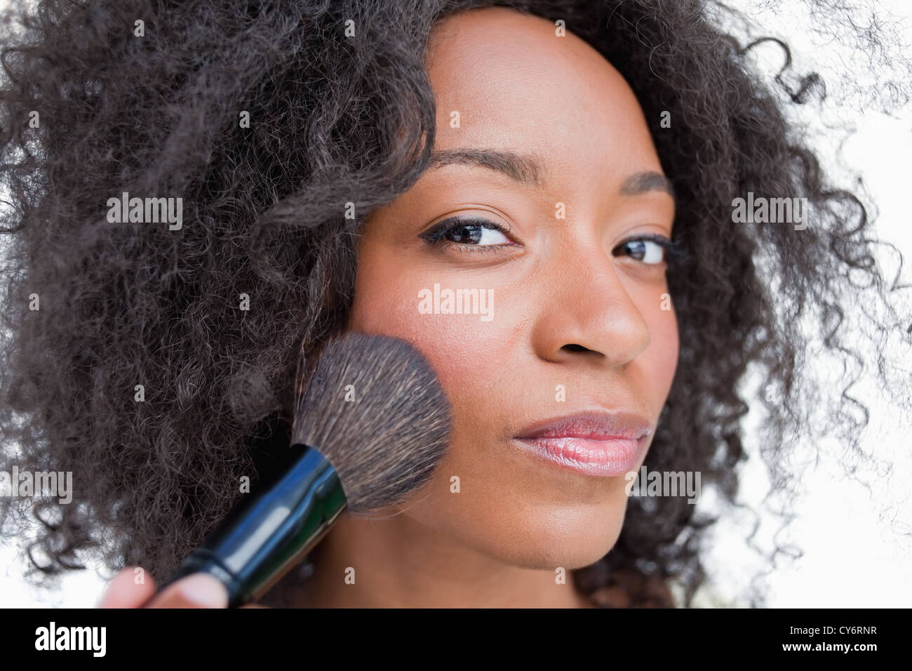 Young serious woman applying blush with powder brush Stock Photo - Alamy