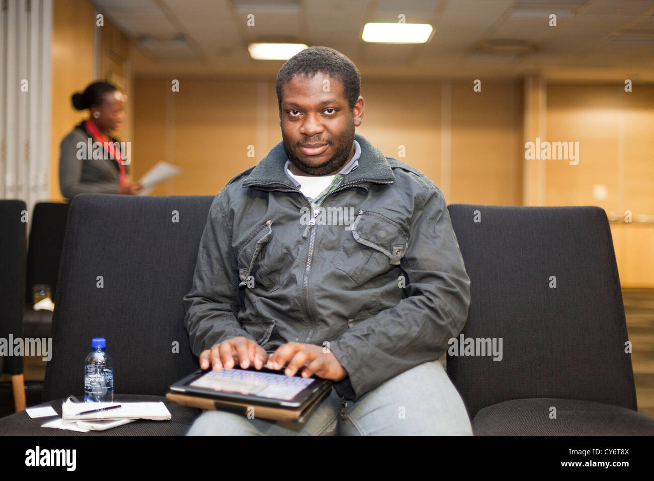 Black male African university student in classroom taking notes on ...