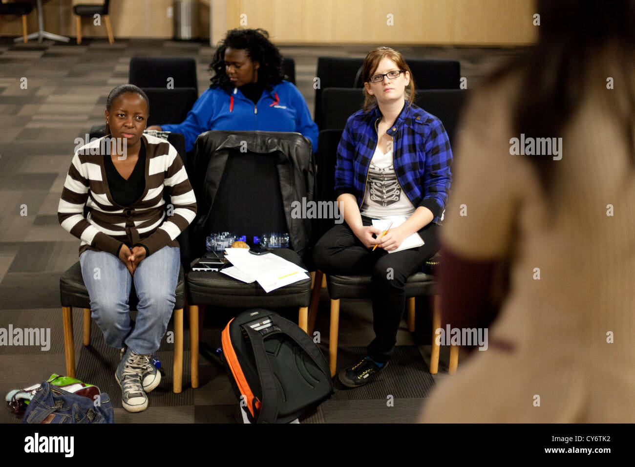 Three female African university students in classroom learning from ...
