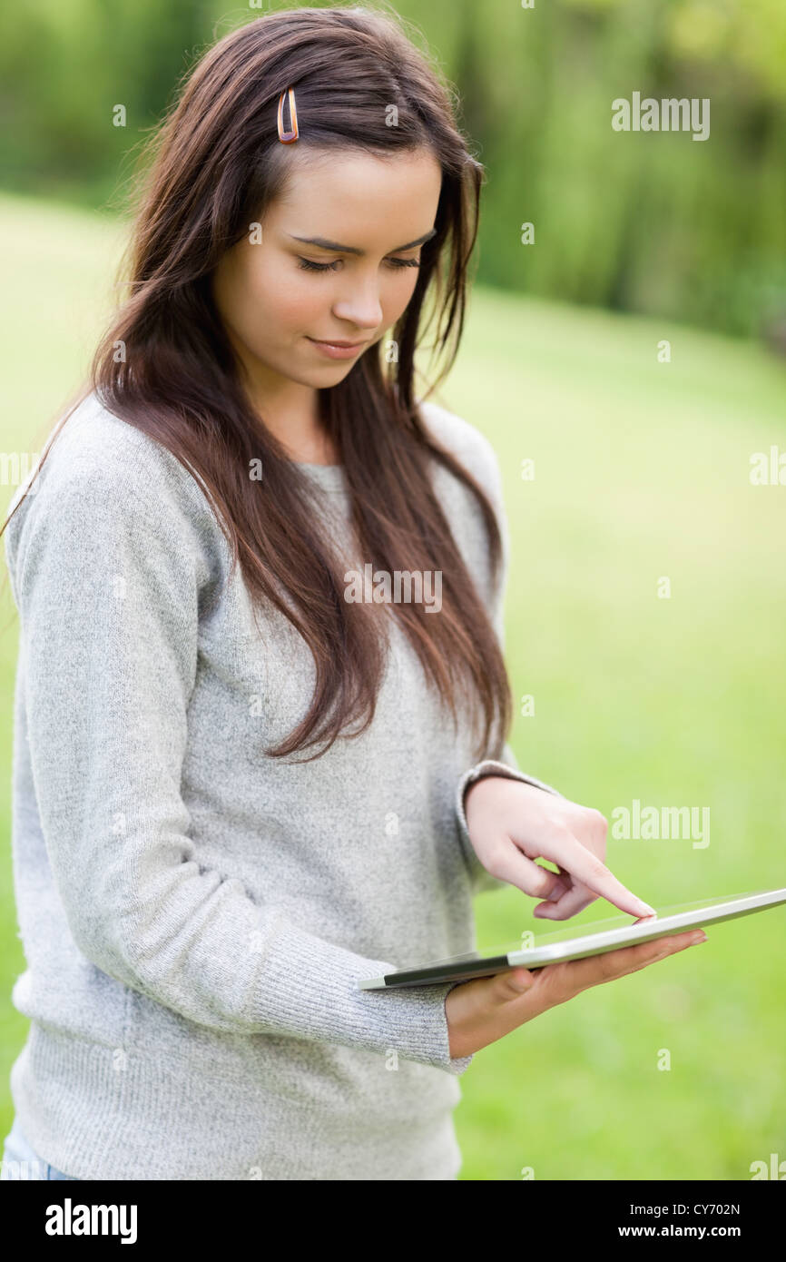 Young woman standing up while using her tablet computer Stock Photo - Alamy