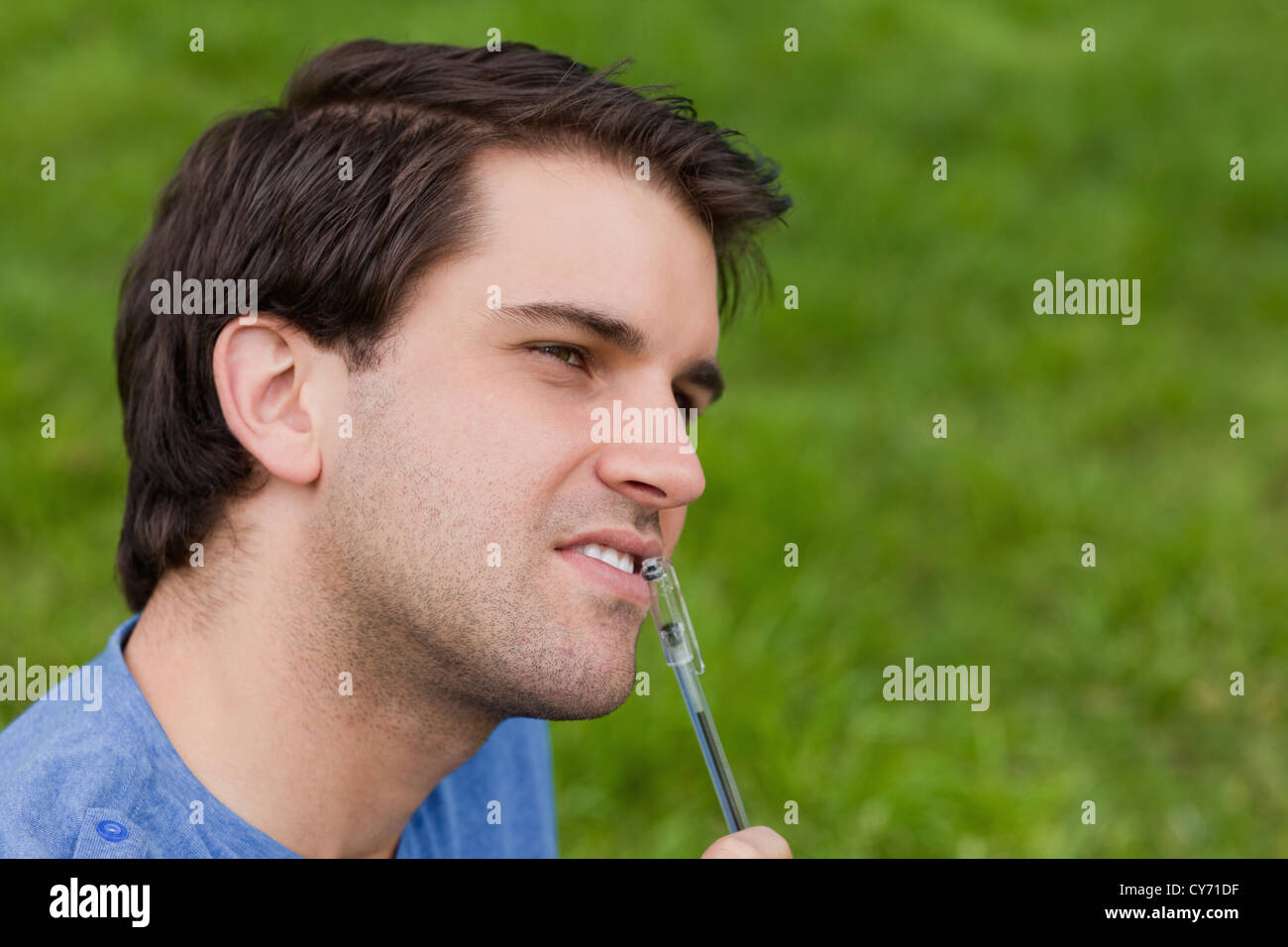 Thoughtful young man holding his pen is thinking Stock Photo - Alamy