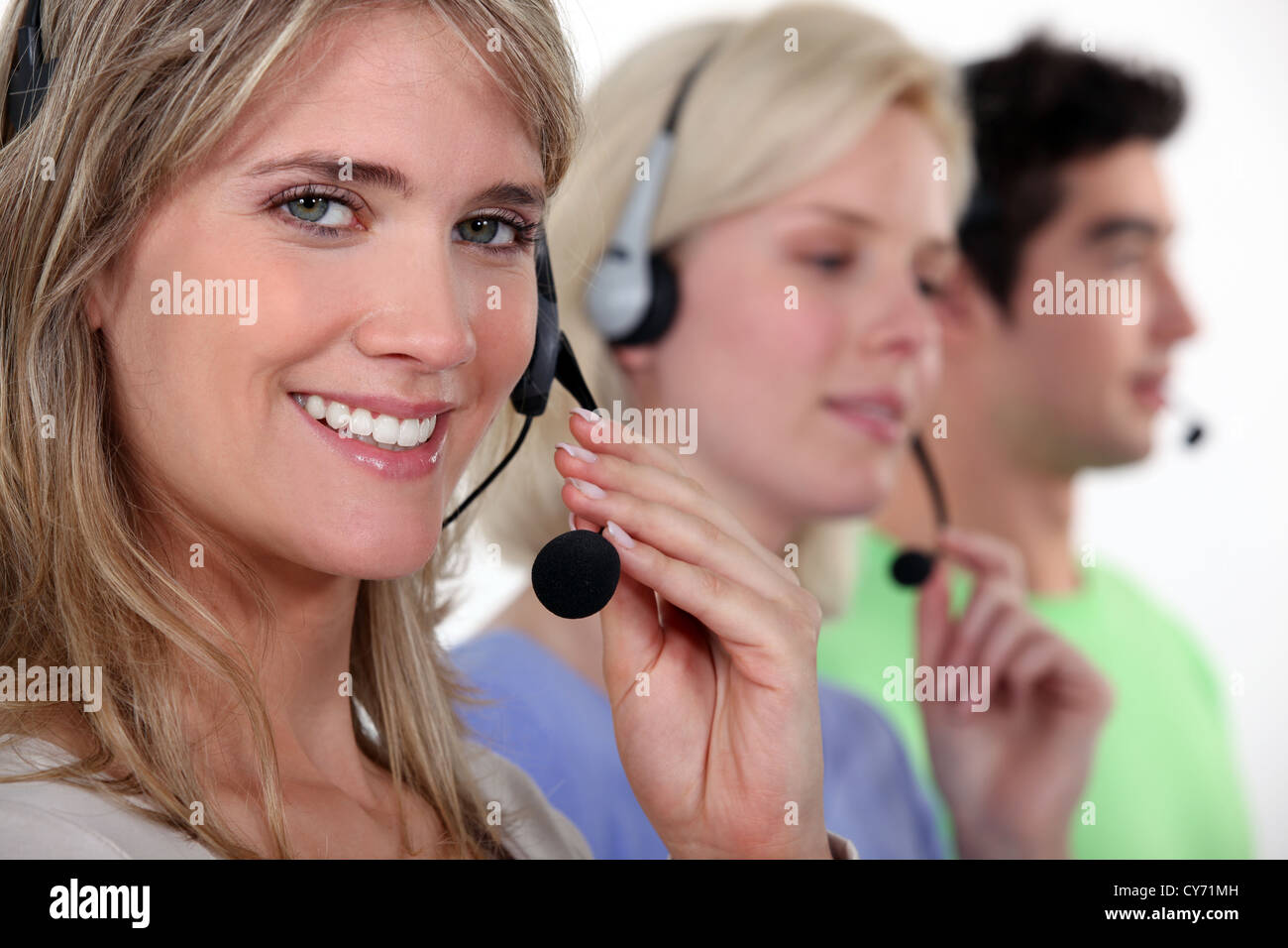 Woman and colleagues wearing headsets Stock Photo - Alamy