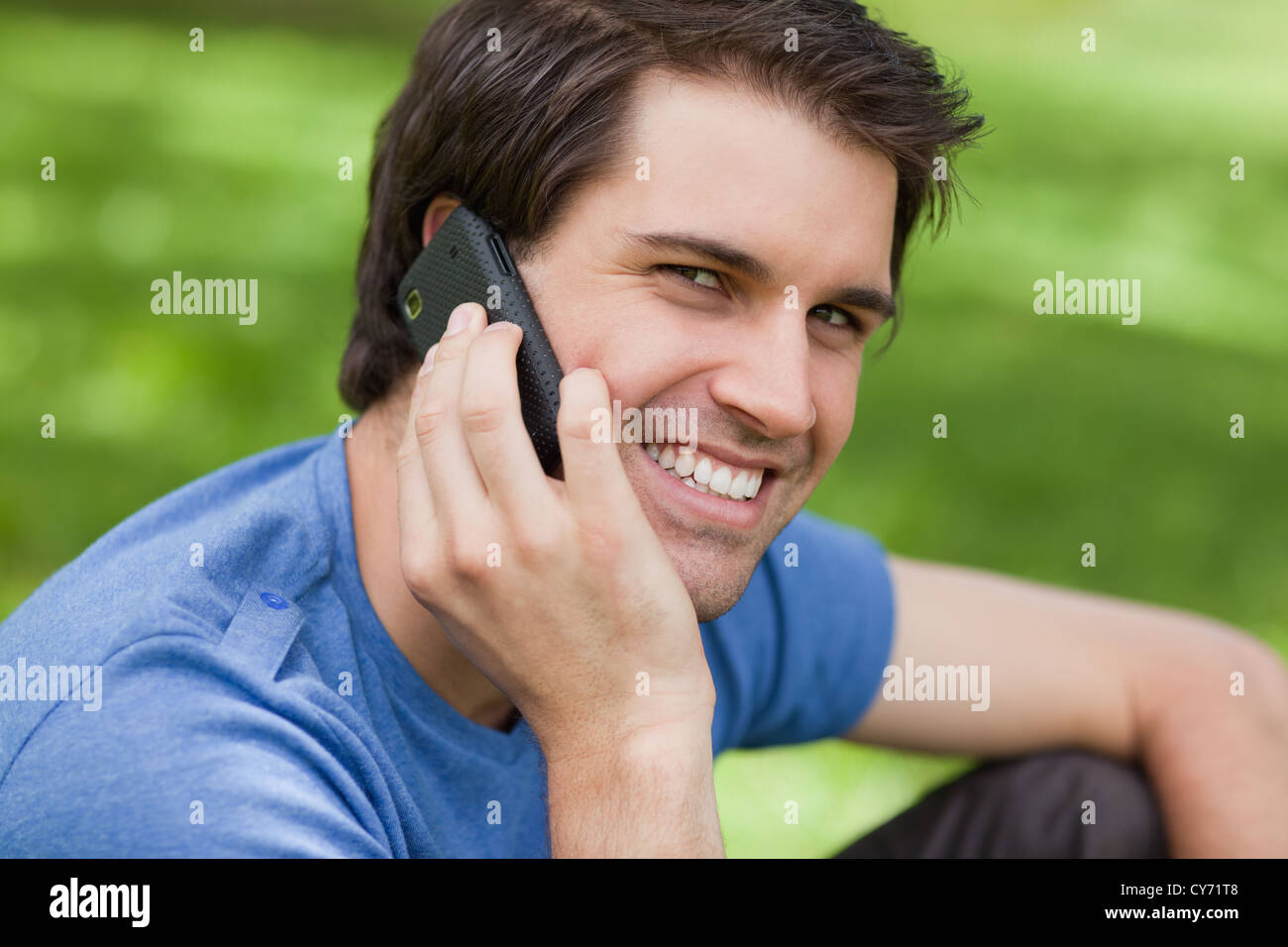 Smiling young man talking on the phone Stock Photo - Alamy