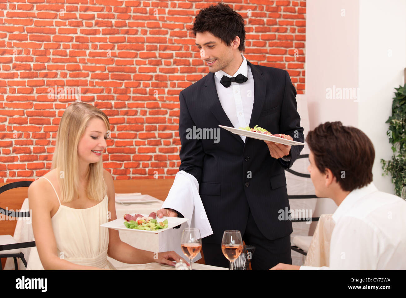 Waiter serving plate of food Stock Photo - Alamy
