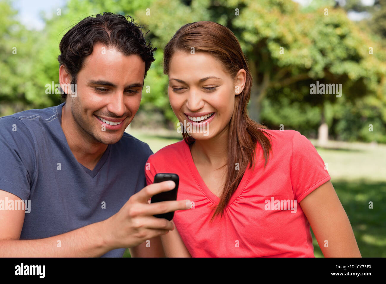 Two friends one on a mobile phone hi-res stock photography and images ...