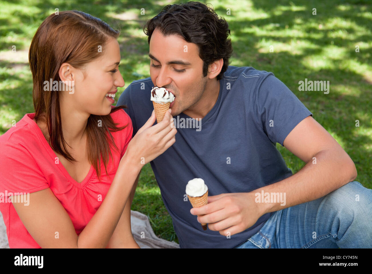 Woman feeding her friend ice cream Stock Photo - Alamy