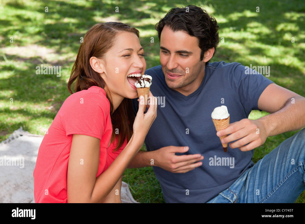 Woman eating ice cream while sitting with her friend Stock Photo - Alamy