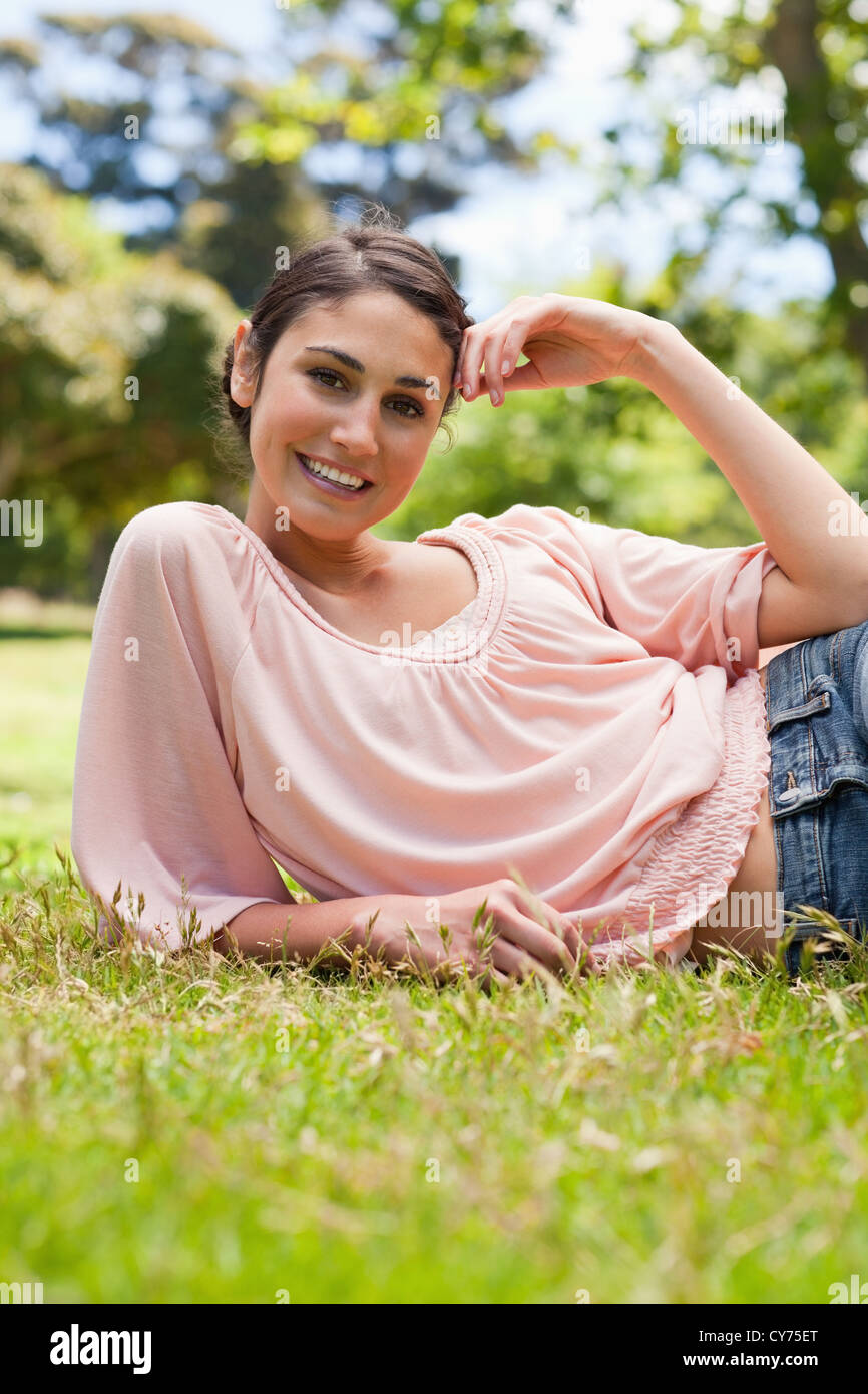 Smiling woman resting her head against her arm while lying down Stock ...