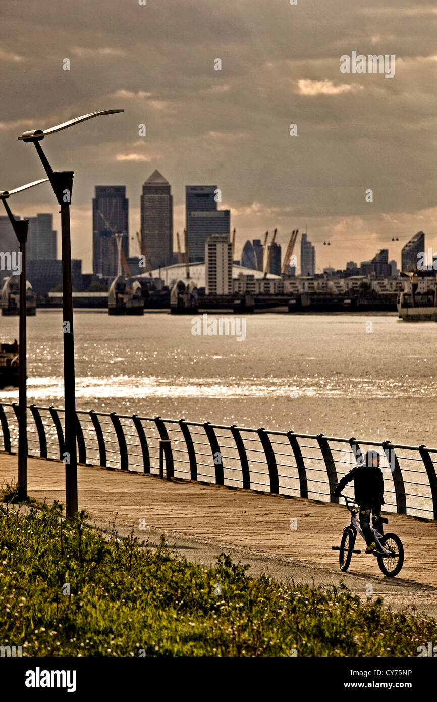 Young boy riding his BMX bike on the Thames River path at Woolwich ...