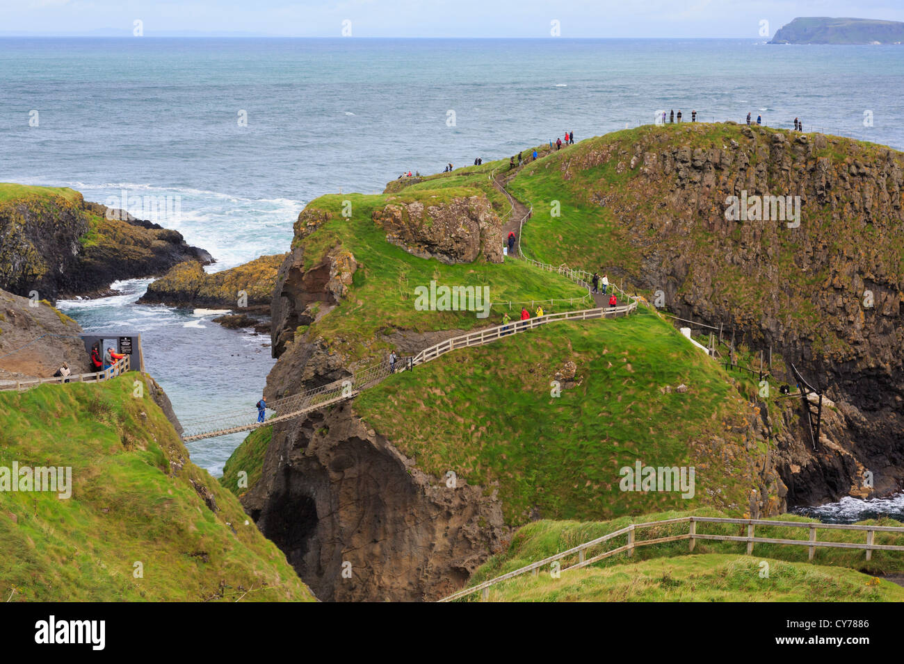 Tourists on Carrick Island with Carrick-a-Rede Rope Bridge on the north ...