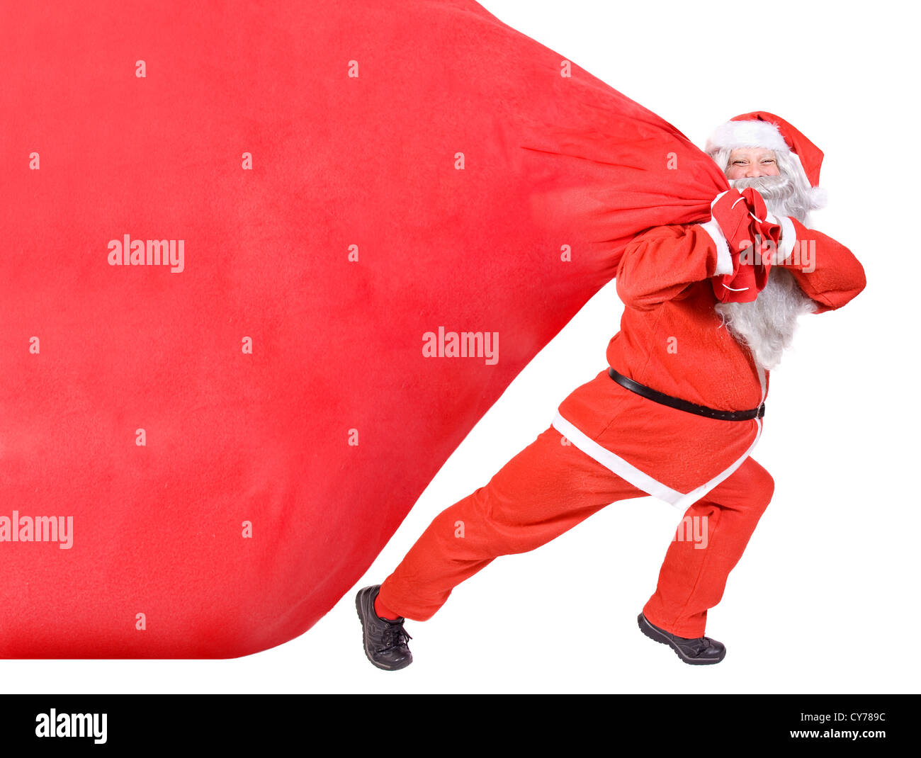 Santa Claus pulls a big heavy bag Stock Photo - Alamy