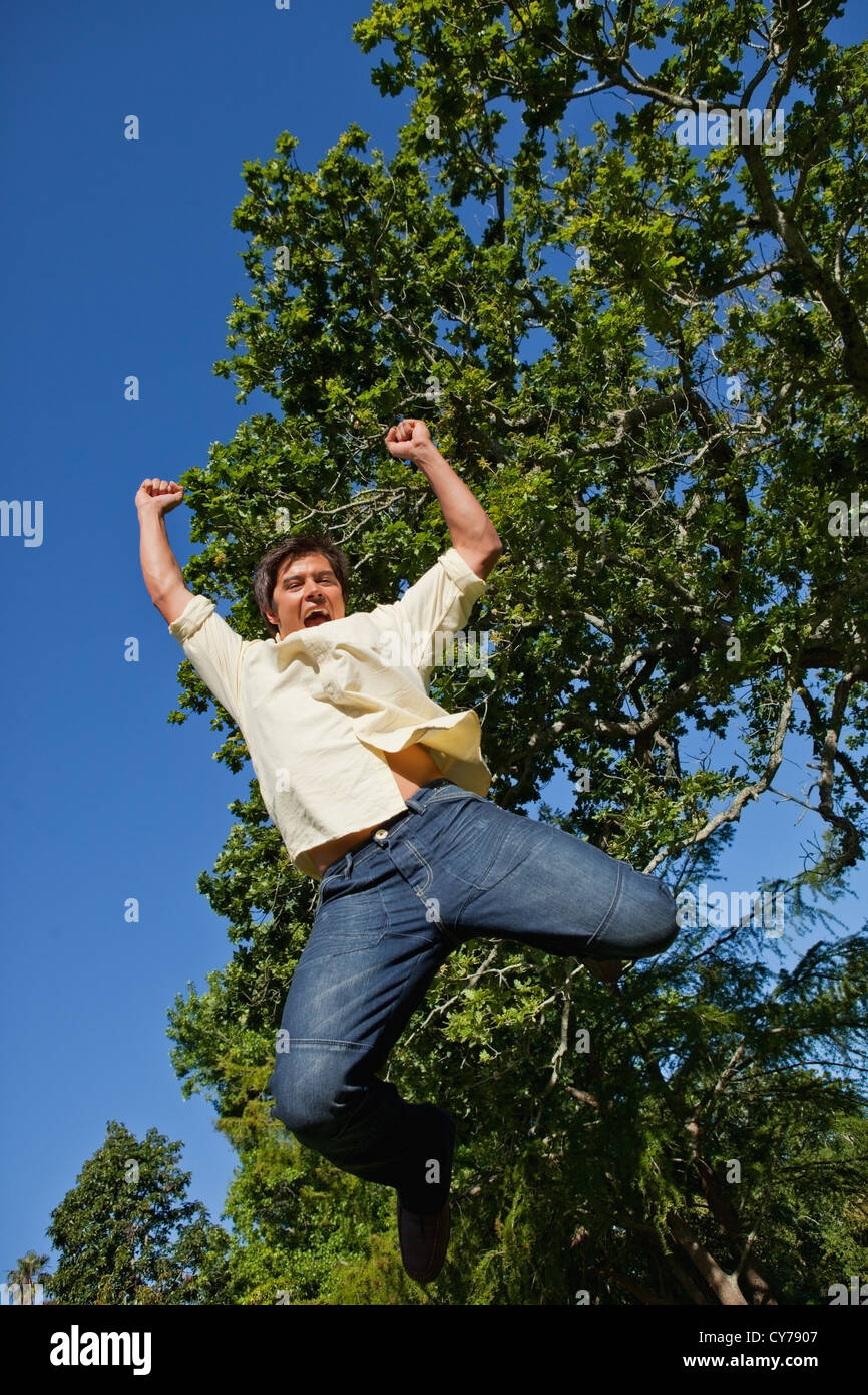Man raising both of his arms and both of his legs as he jumps in ...