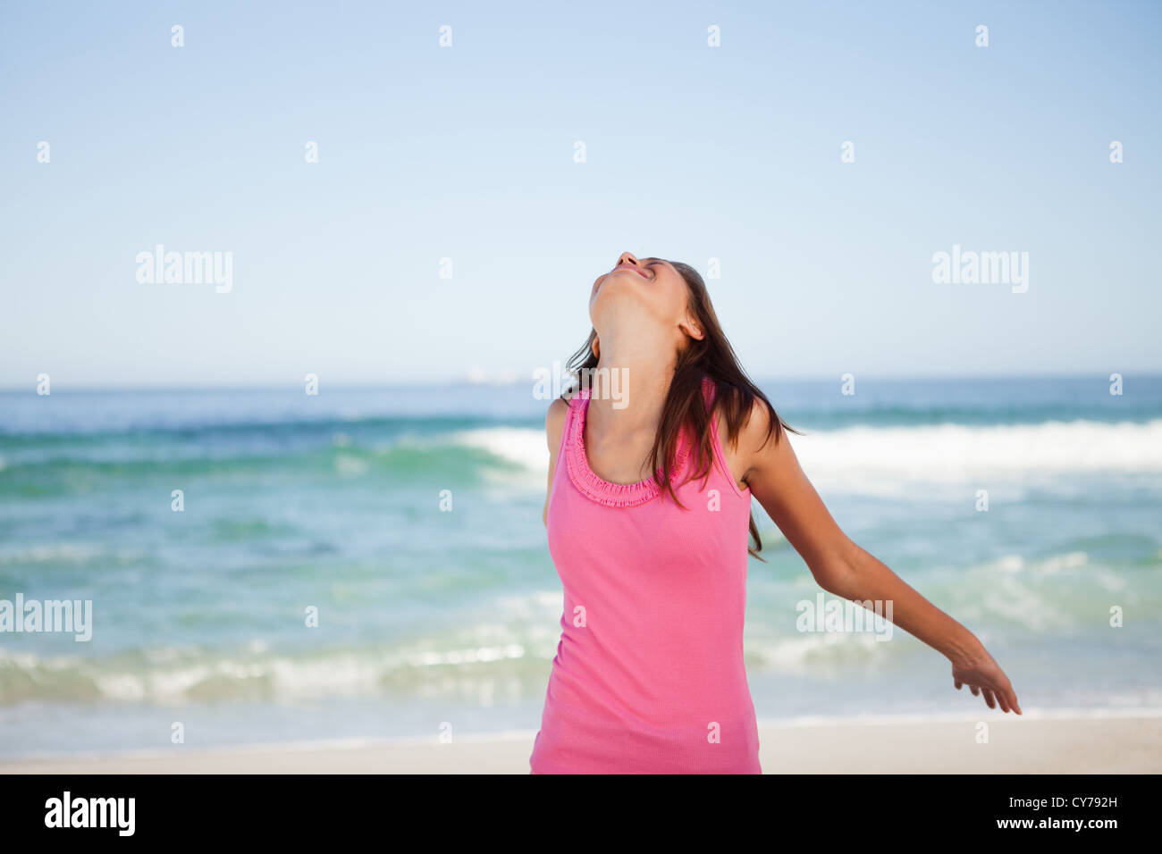 Young relaxed woman standing on the beach with her arms spread Stock ...