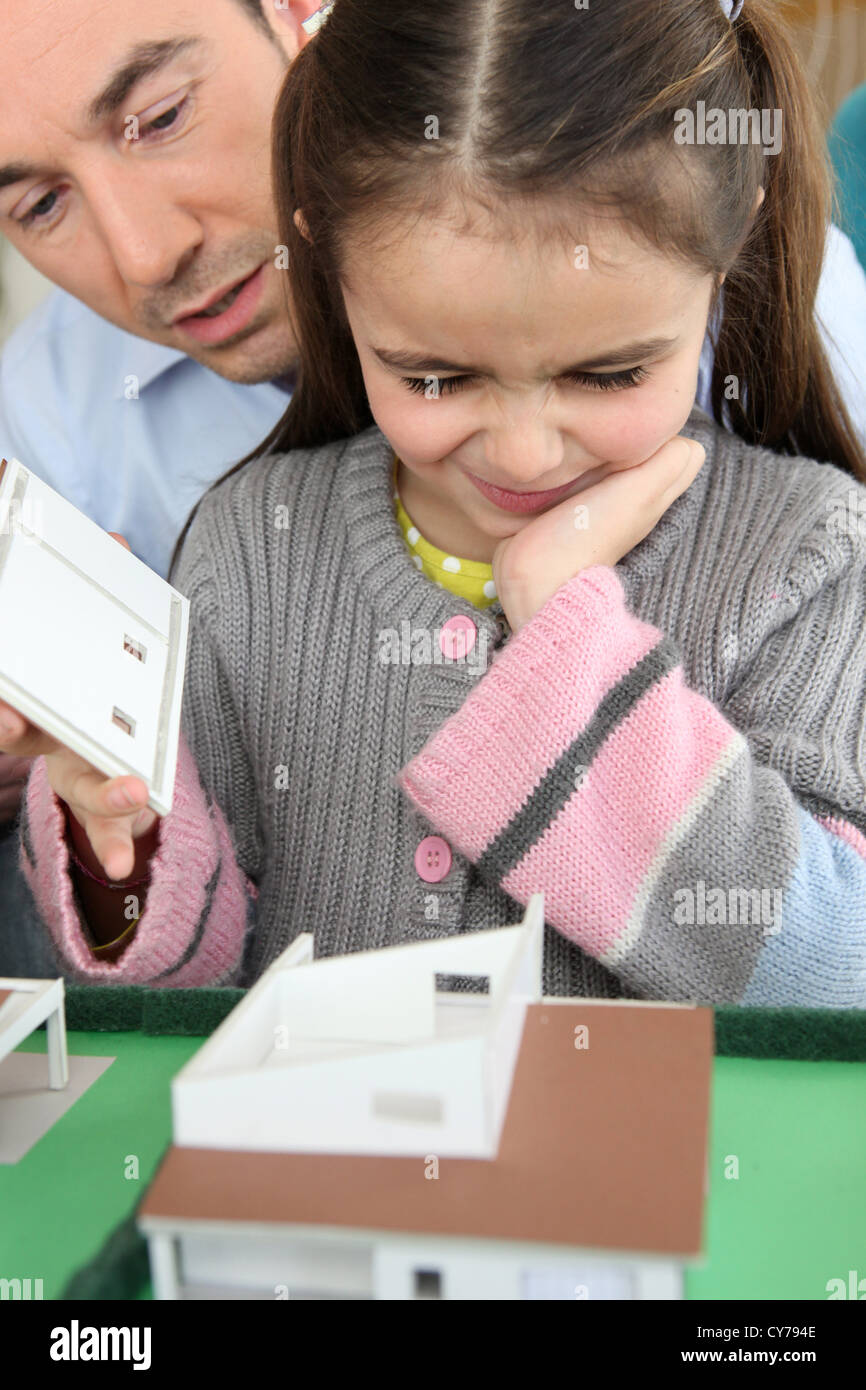 Father and daughter looking at a house model Stock Photo - Alamy