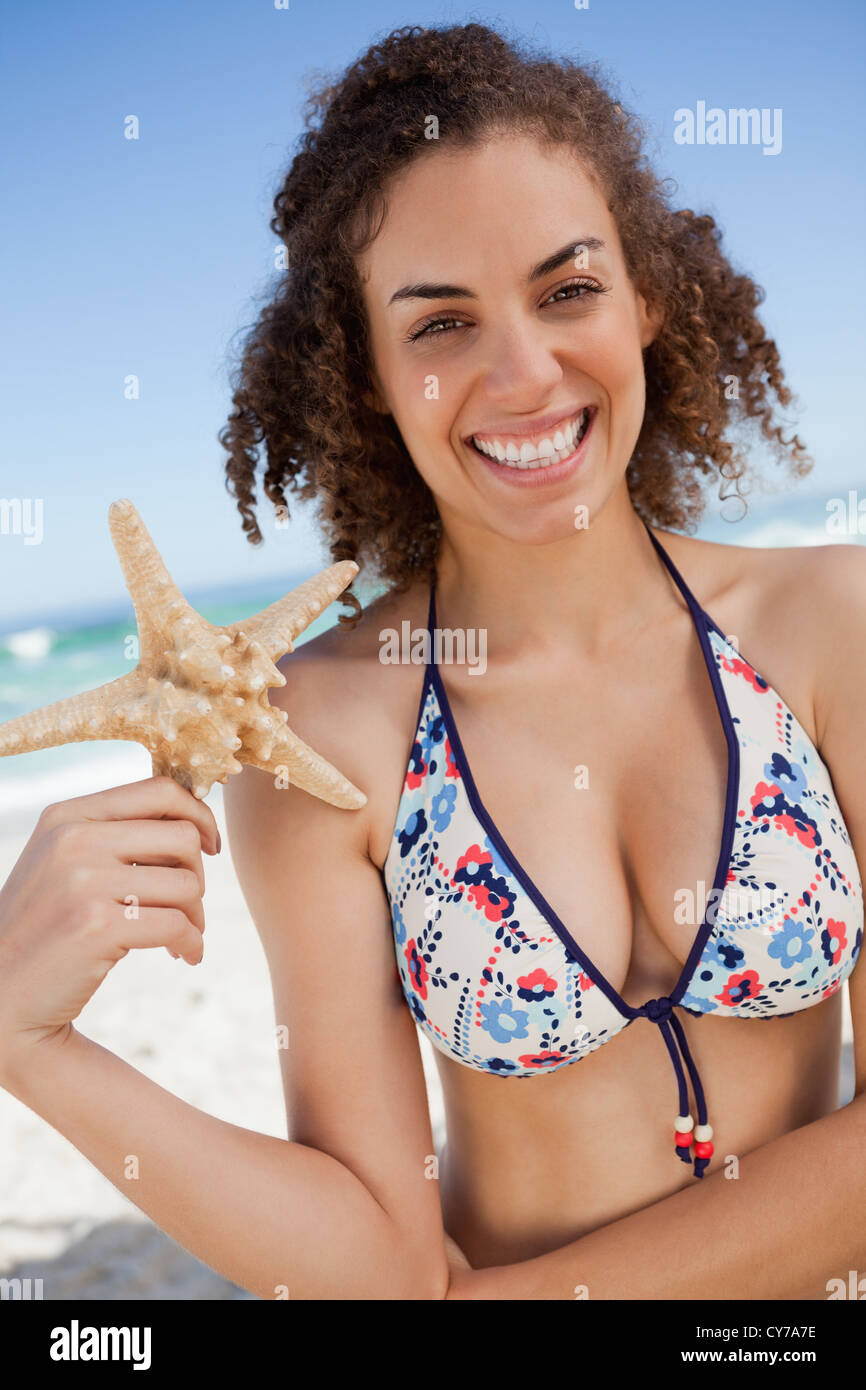 Smiling young woman discovering a starfish on the beach Stock Photo - Alamy Smiling young woman discovering a starfish on the beach Stock Photo - Alamy