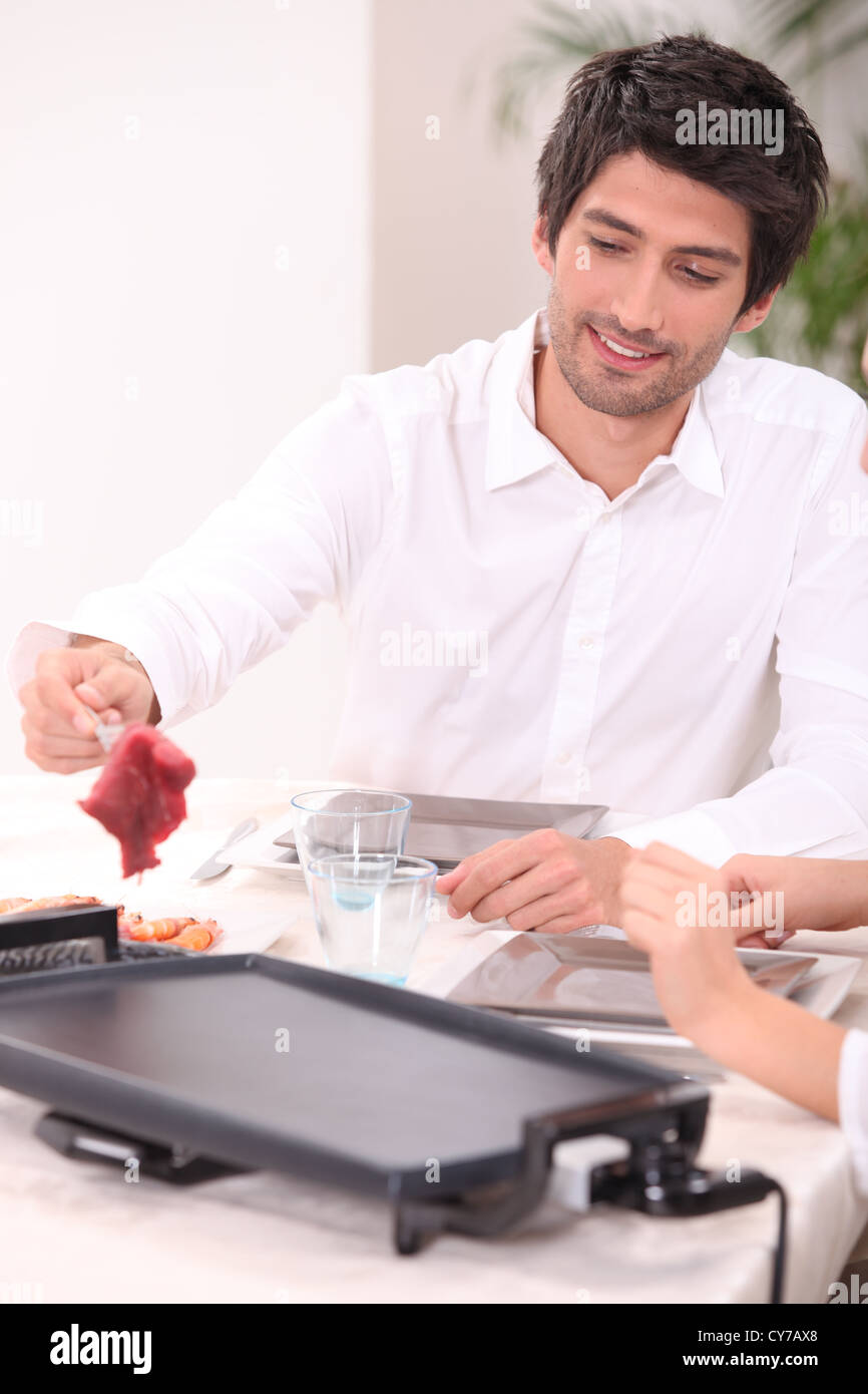 Man cooking steak on a table top plate Stock Photo - Alamy