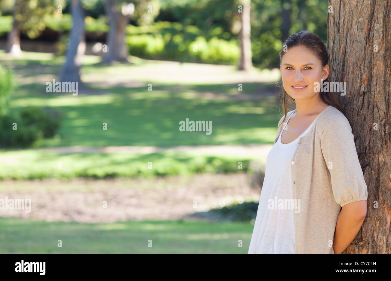 Female leaning against tree hi-res stock photography and images - Alamy