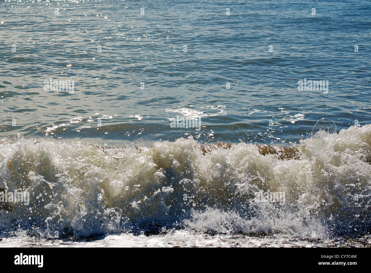 Breaking waves, swash and backwash over shingle on the beach at ...