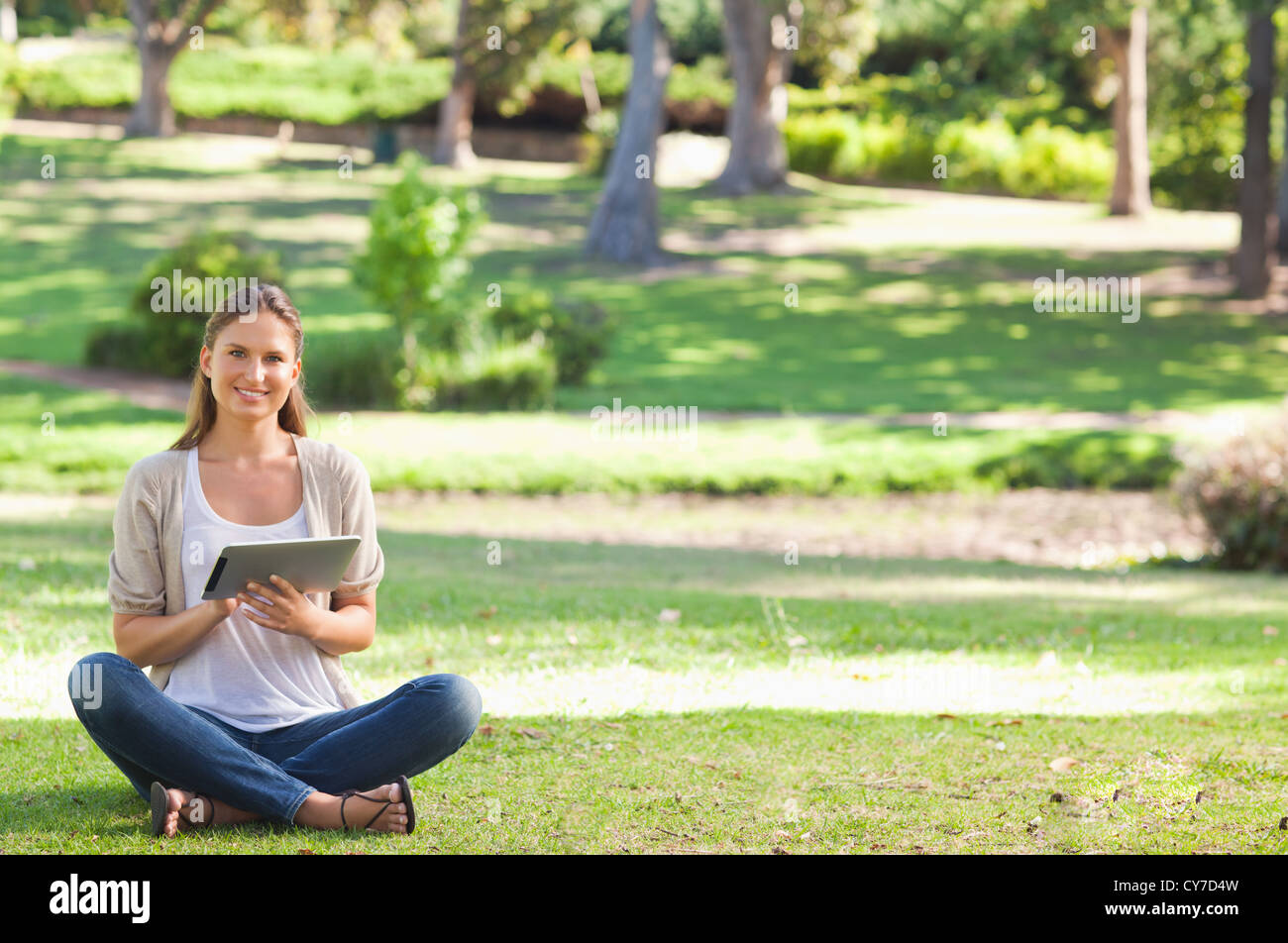 Woman in the park using her tablet computer Stock Photo - Alamy