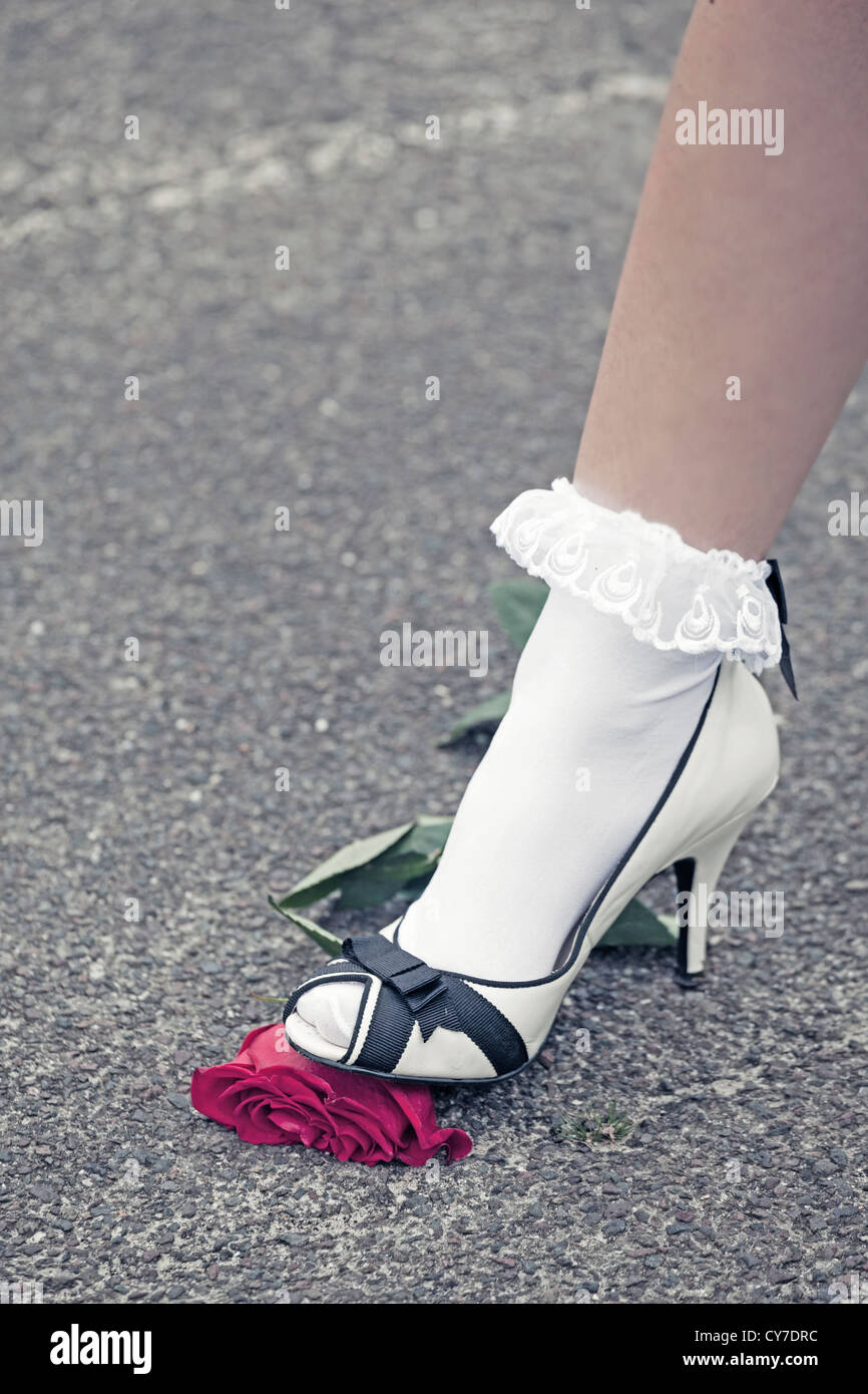 foot of a woman is stepping on a red rose Stock Photo - Alamy